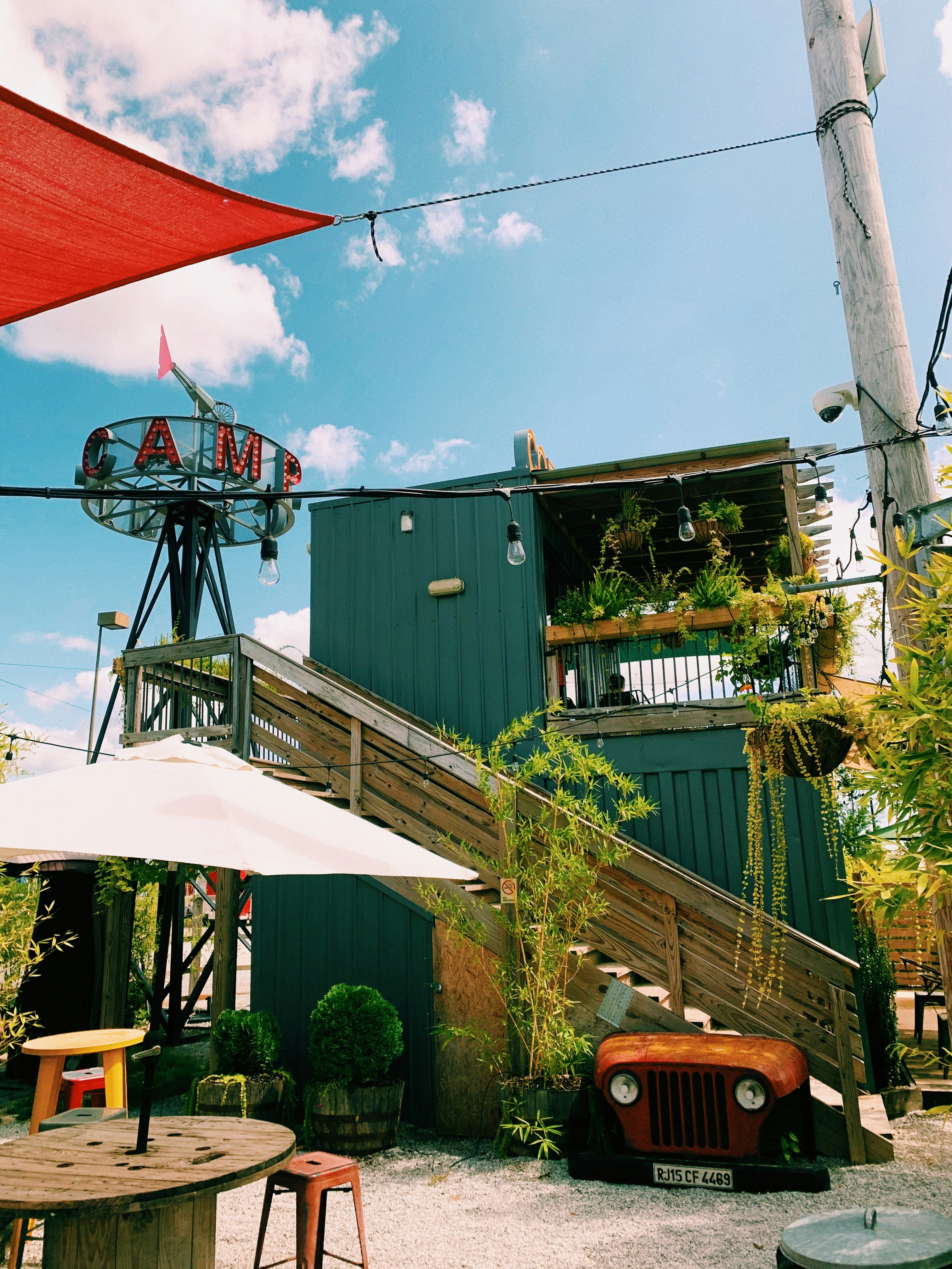 Lounge beneath the Neon Camp Sign and Weathered Jeep