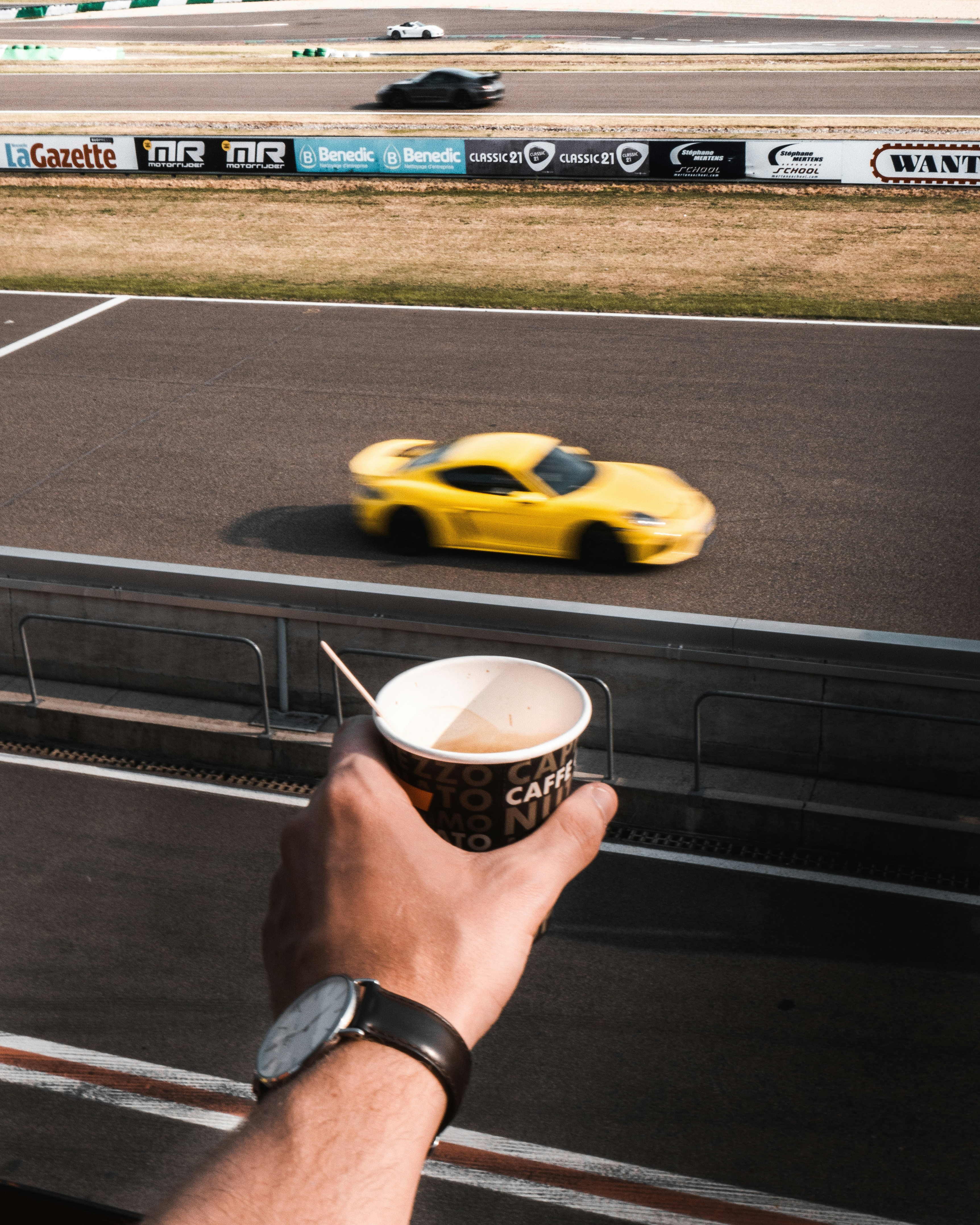 Yellow Blur on the Track: A Moment of Coffee and Speed