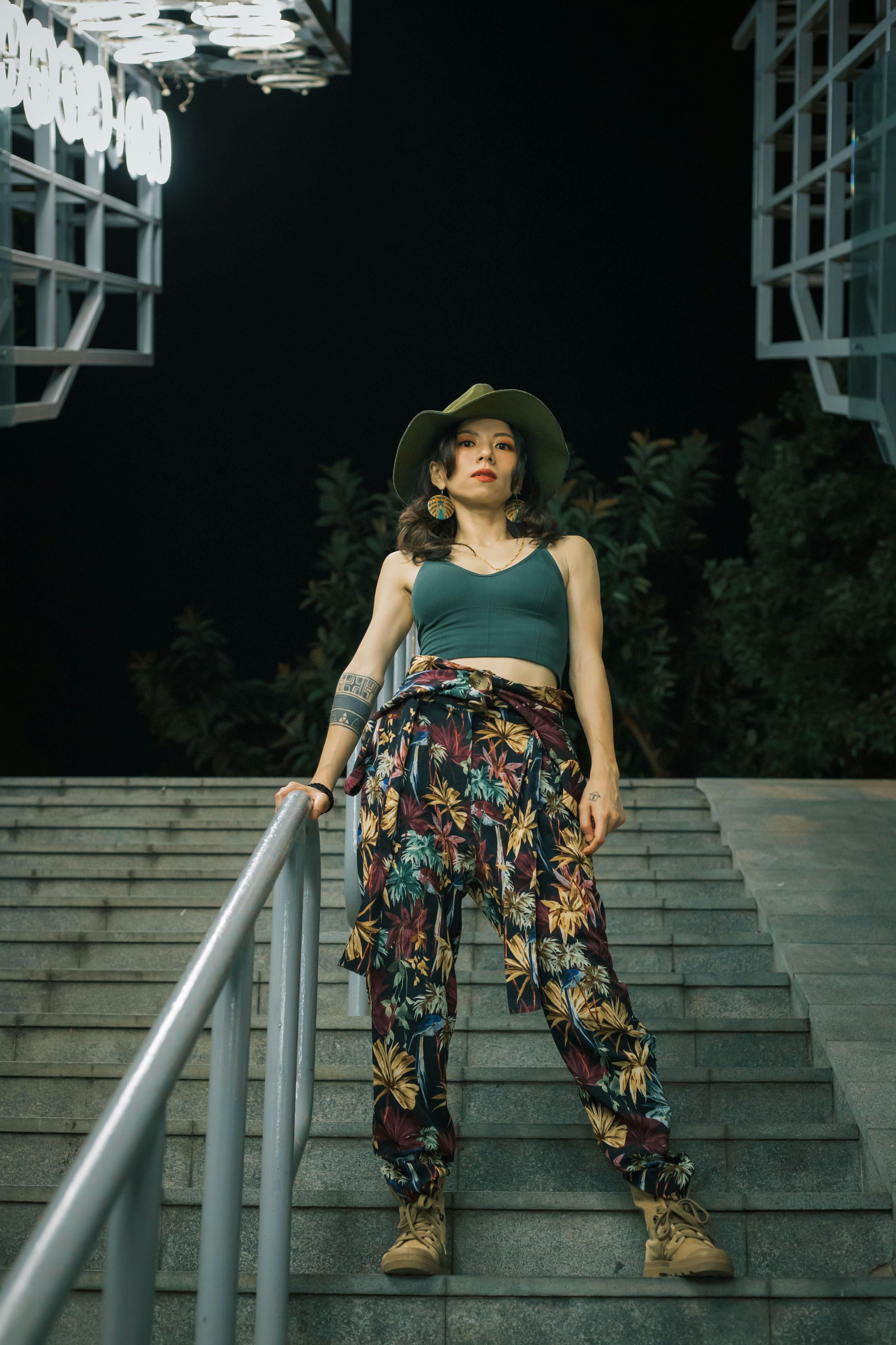 Eco-Chic Night Stroll: Green Top, Floral Pants, and Neon Night