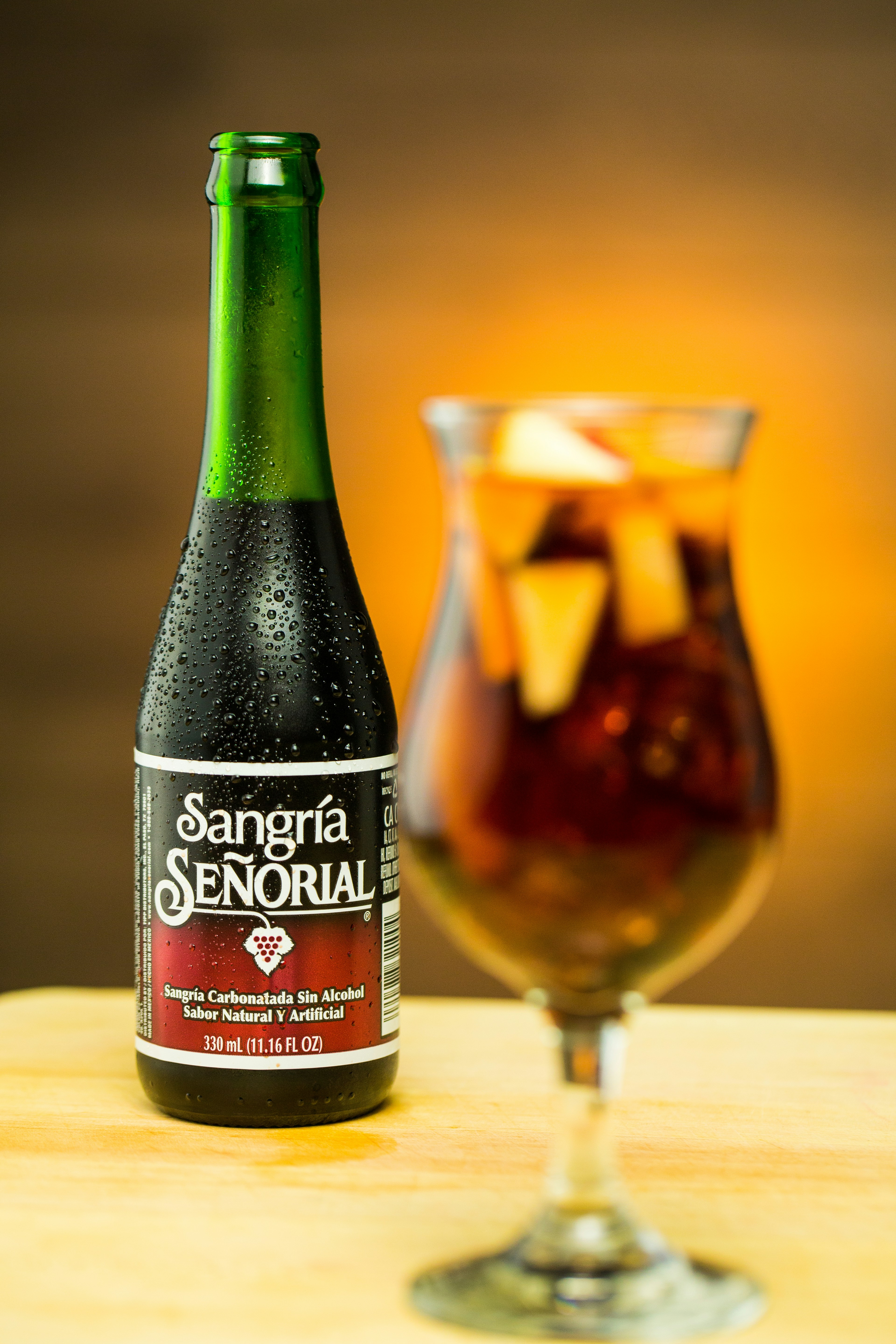 Emerald Bottle, Amber Glow: A Close-Up of Sangría Senorial on Wood