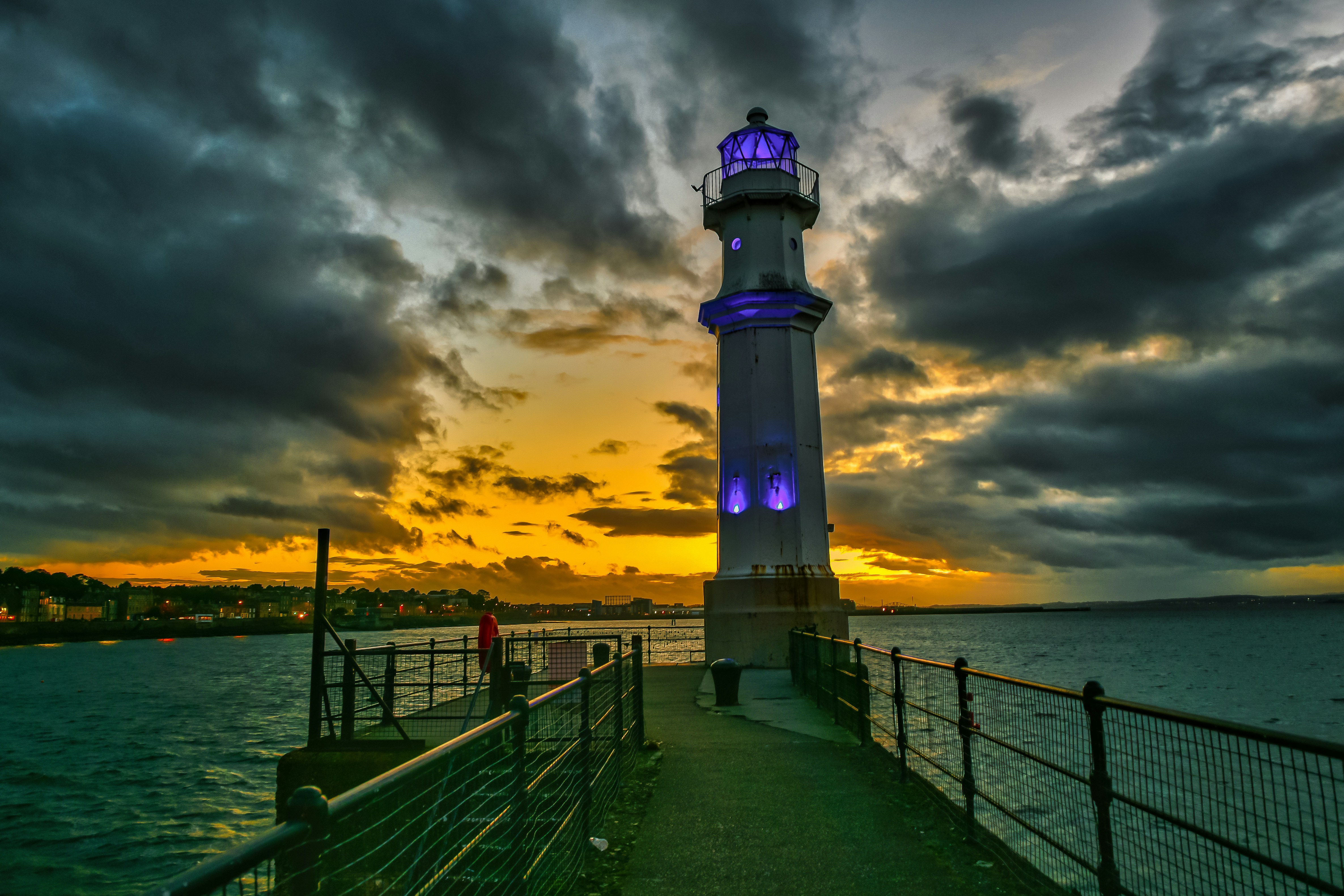 Black and white lighthouse near body of water during sunset photo ...