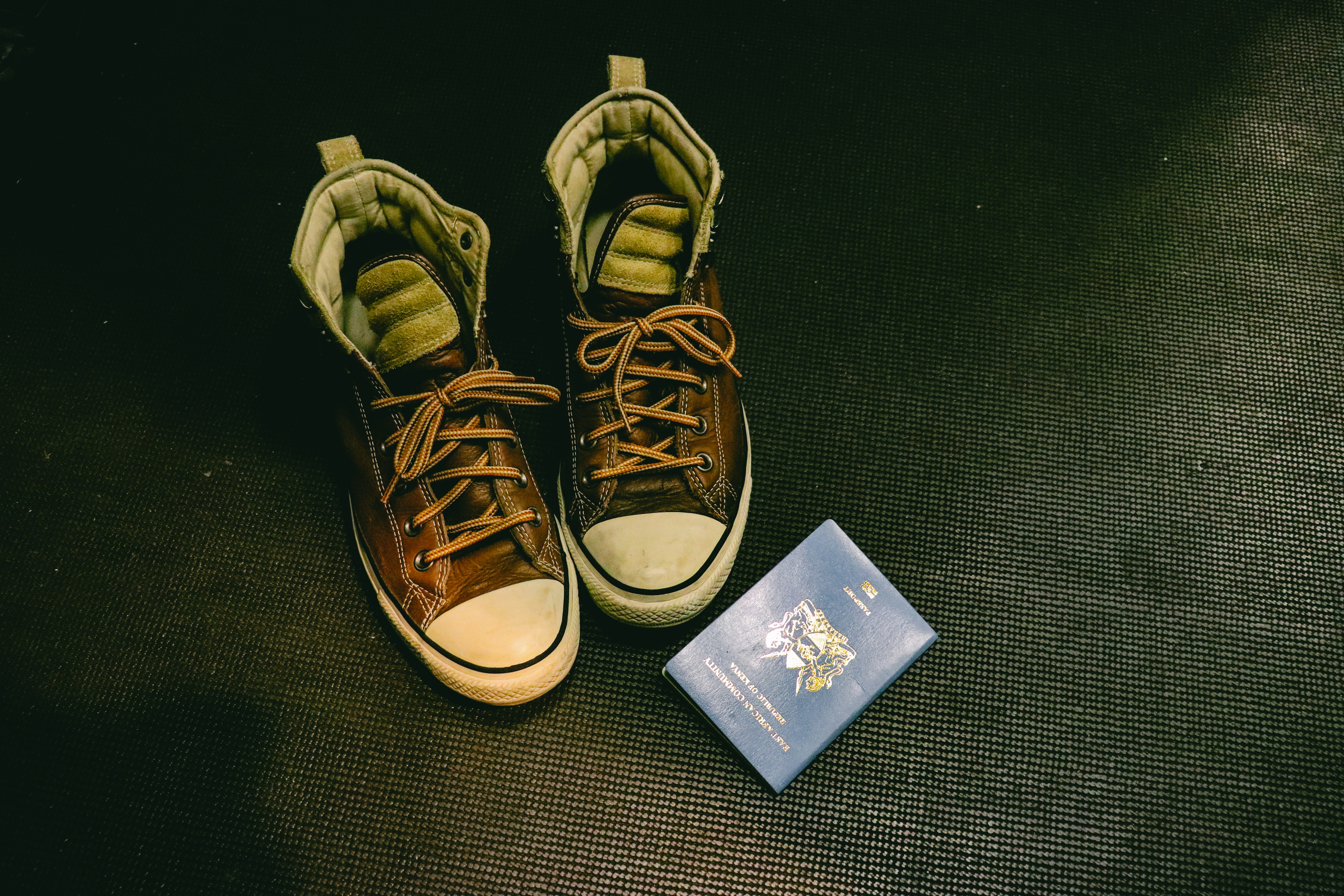 A pair of converse shoes and a Kenyan passport.