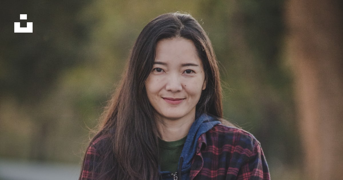 빨간색과 검은색 체크무늬 드레스 셔츠와 회색 바위에 앉아 있는 파란색 데님 청바지를 입은 여자 사진 Unsplash의 무료