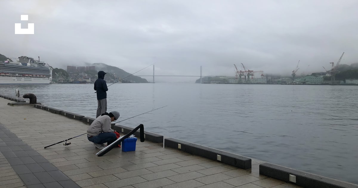 낮 동안 파란색 나무 부두에 서 있는 파란색 재킷과 검은색 바지를 입은 사람 사진 Unsplash의 무료 일본 이미지