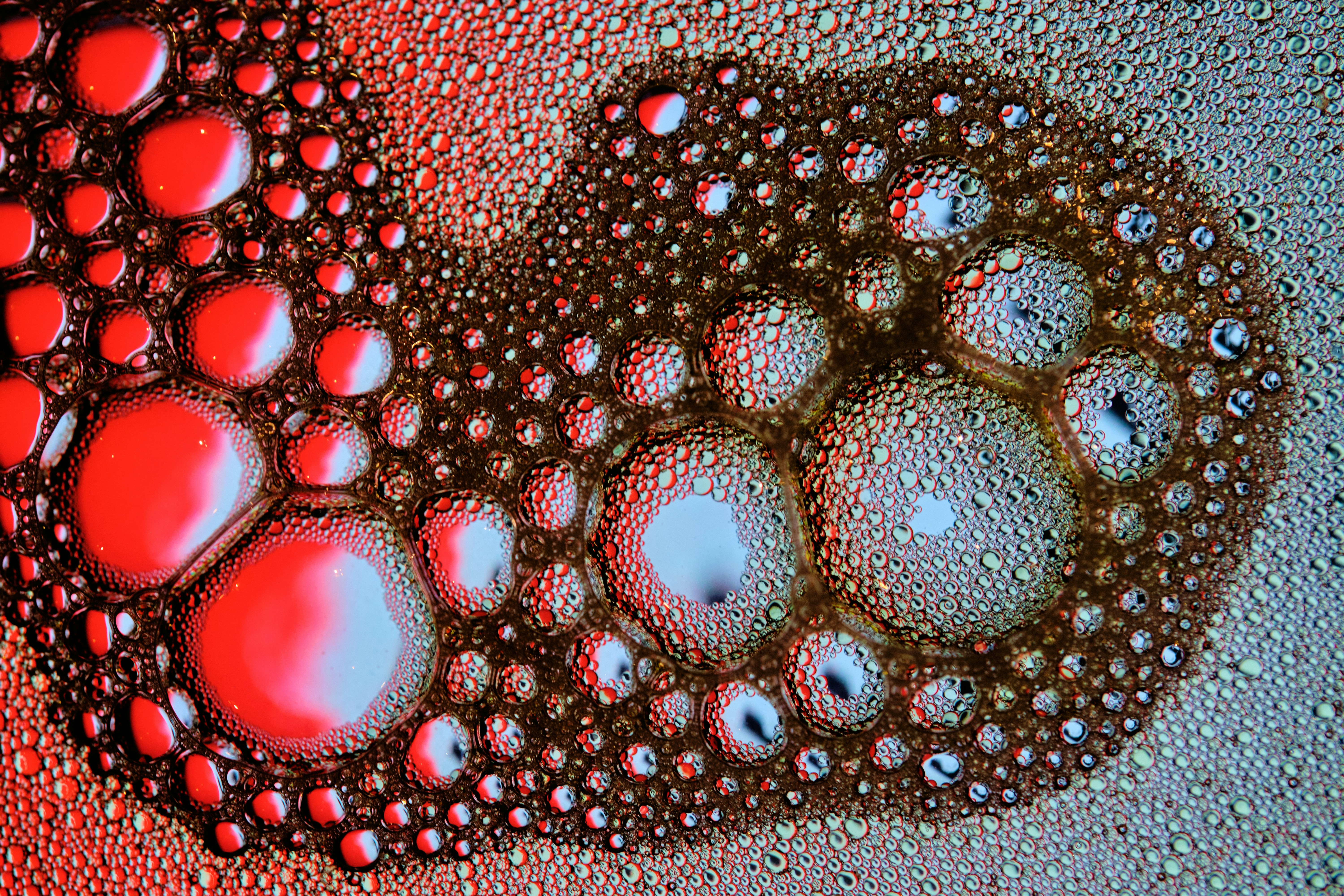 Hidden evil...if you look very closely you might find the evil lurking beneath the surface.  It's in pieces in the oil drops. | black and red round ornament