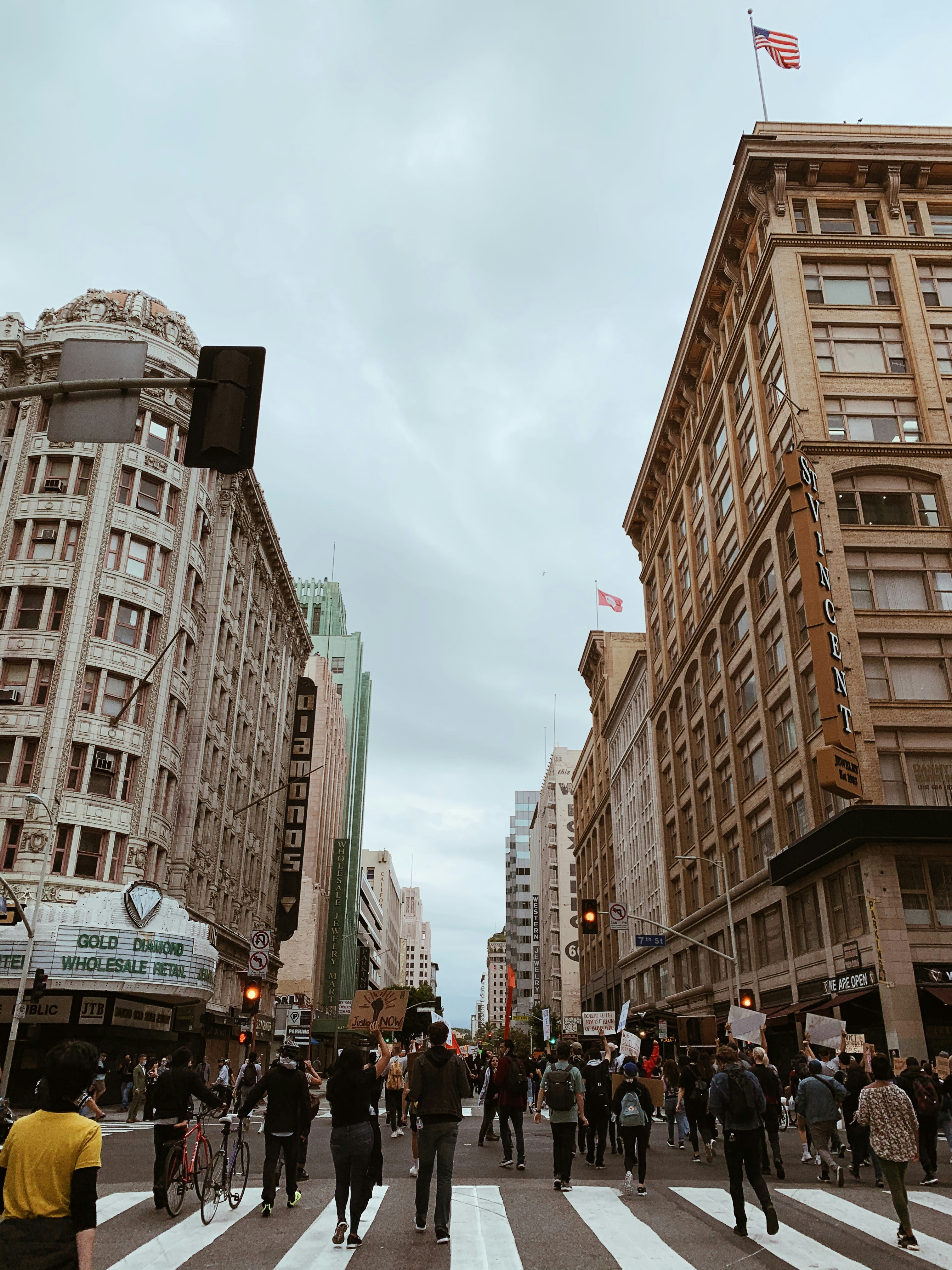 People walking on street between high rise buildings during daytime ...