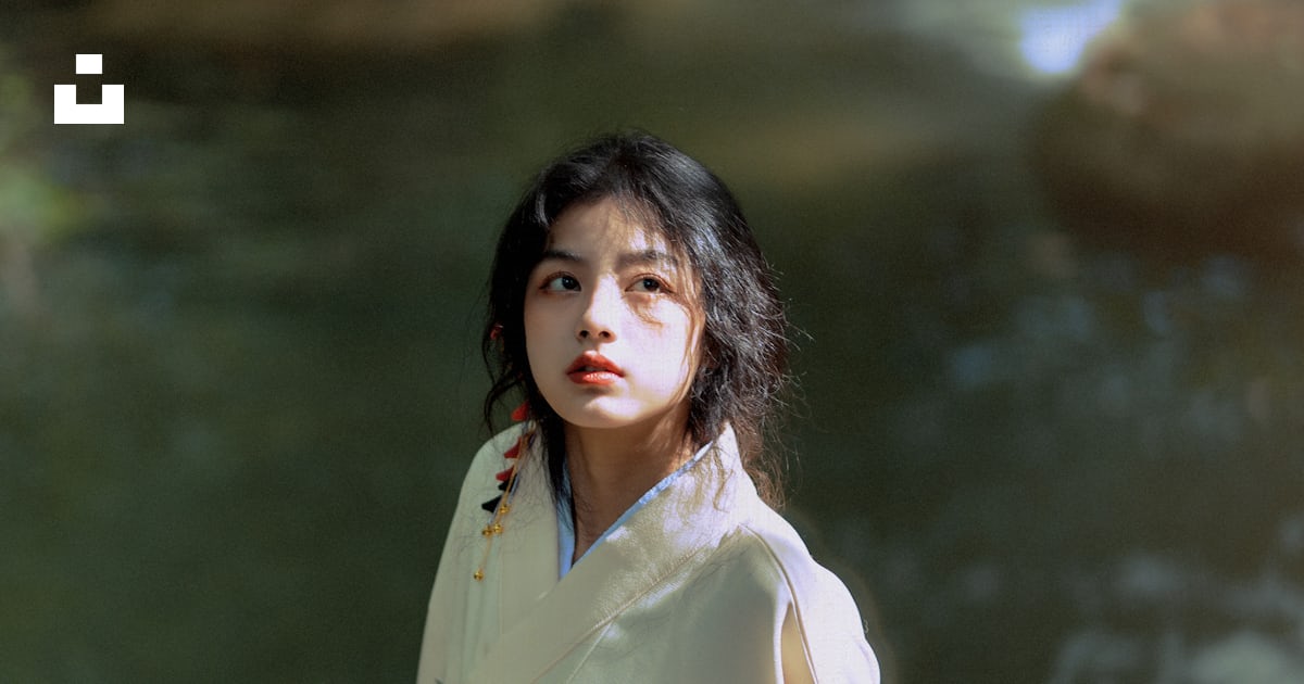 녹색과 흰색 꽃 기모노를 입은 여자는 낮에 강 근처의 바위에 앉아 사진 Unsplash의 무료 사람 이미지