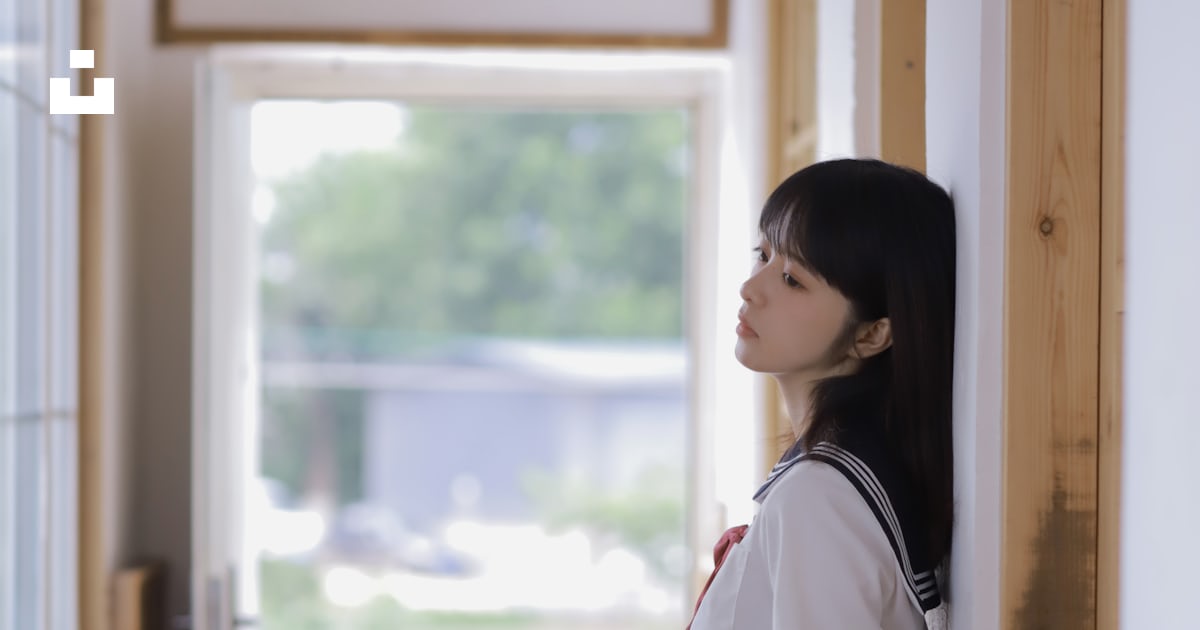 낮 동안 창문 근처에 서 있는 흰 셔츠와 검은 치마를 입은 여자 사진 Unsplash의 무료 여자 이미지