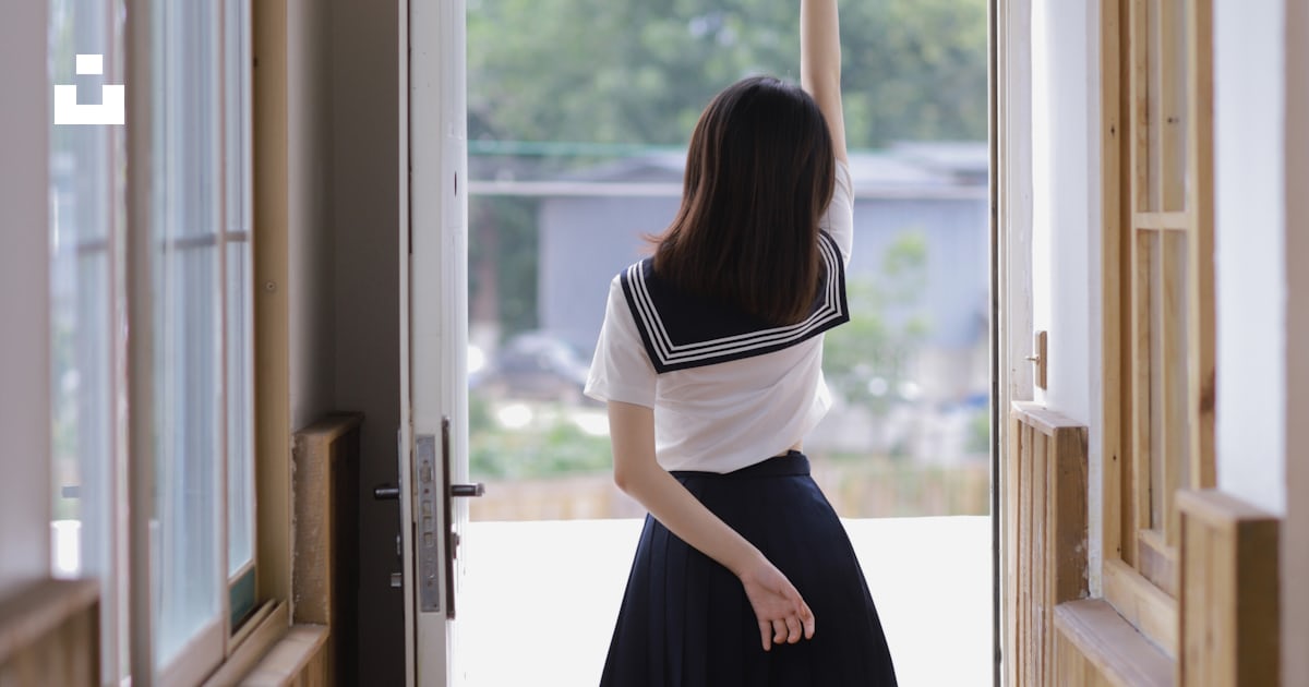 흰 셔츠와 검은 치마를 입은 여자가 창가에 서 있다 사진 Unsplash의 무료 회색 이미지