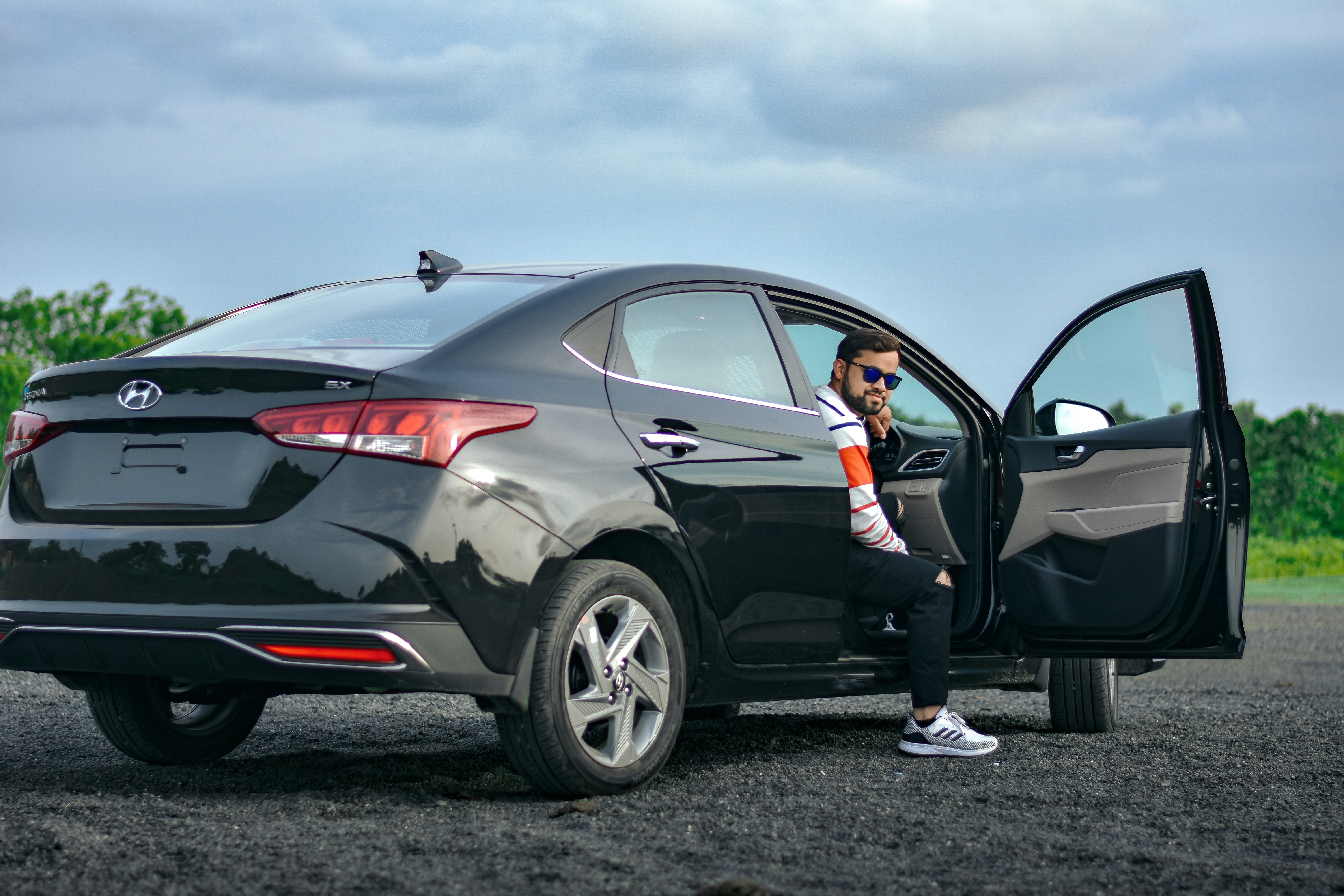 Open Door Moment: Quiet Confidence by the Sedan