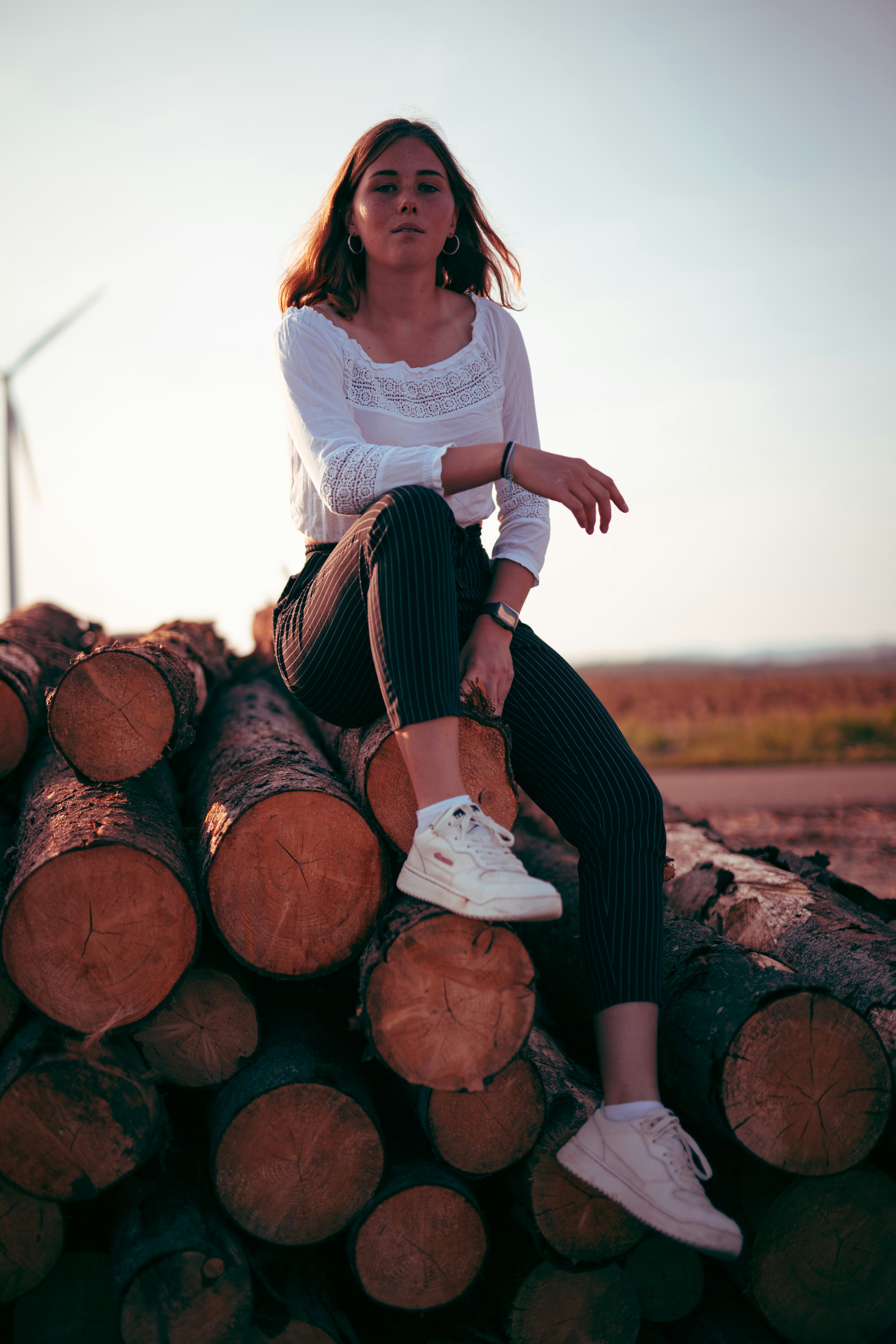 Edge of Light: Portrait atop a Log Pile at Golden Hour