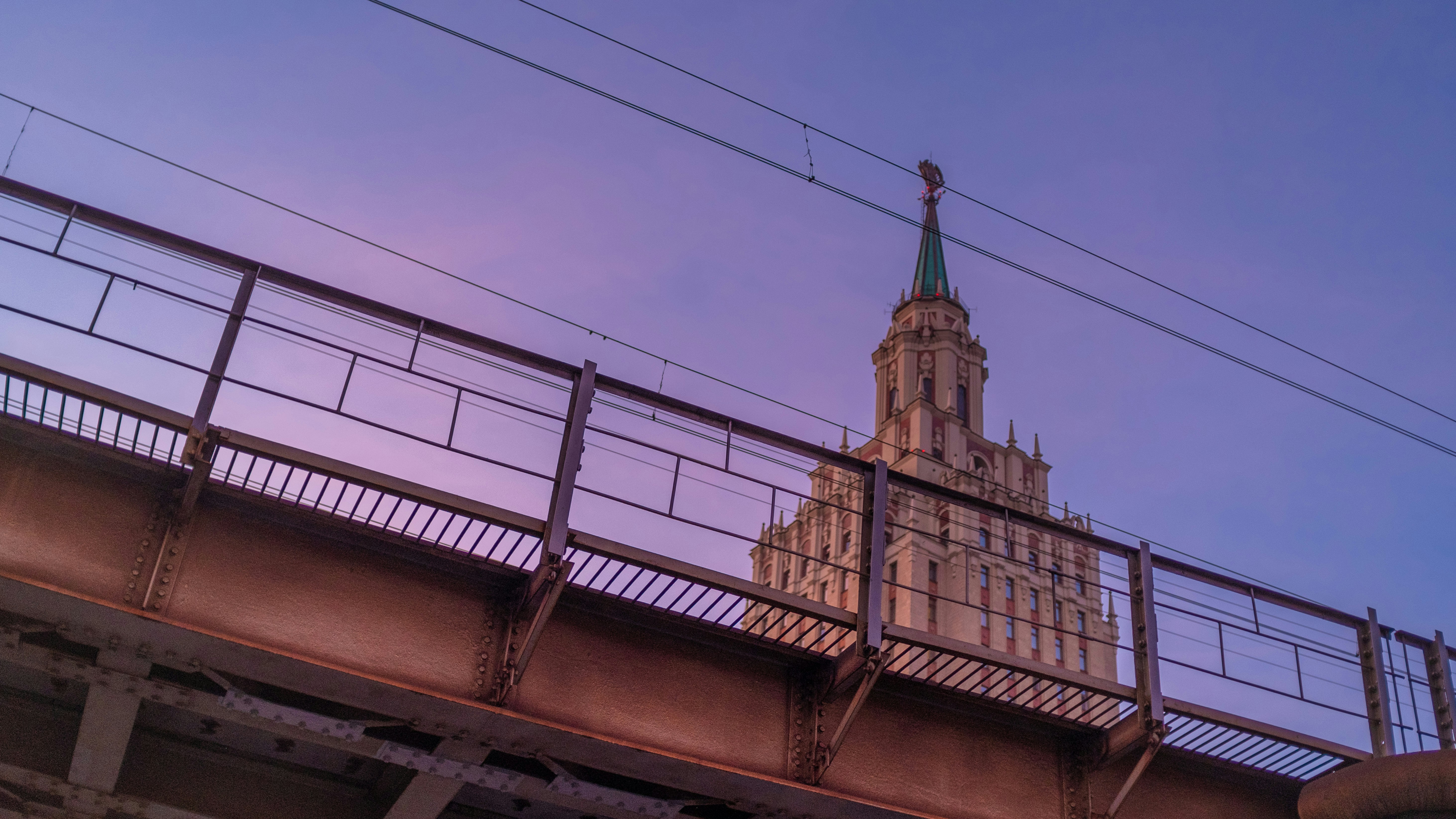 Spire Beyond the Rails: Dusk Framing of a Green-Capped Tower
