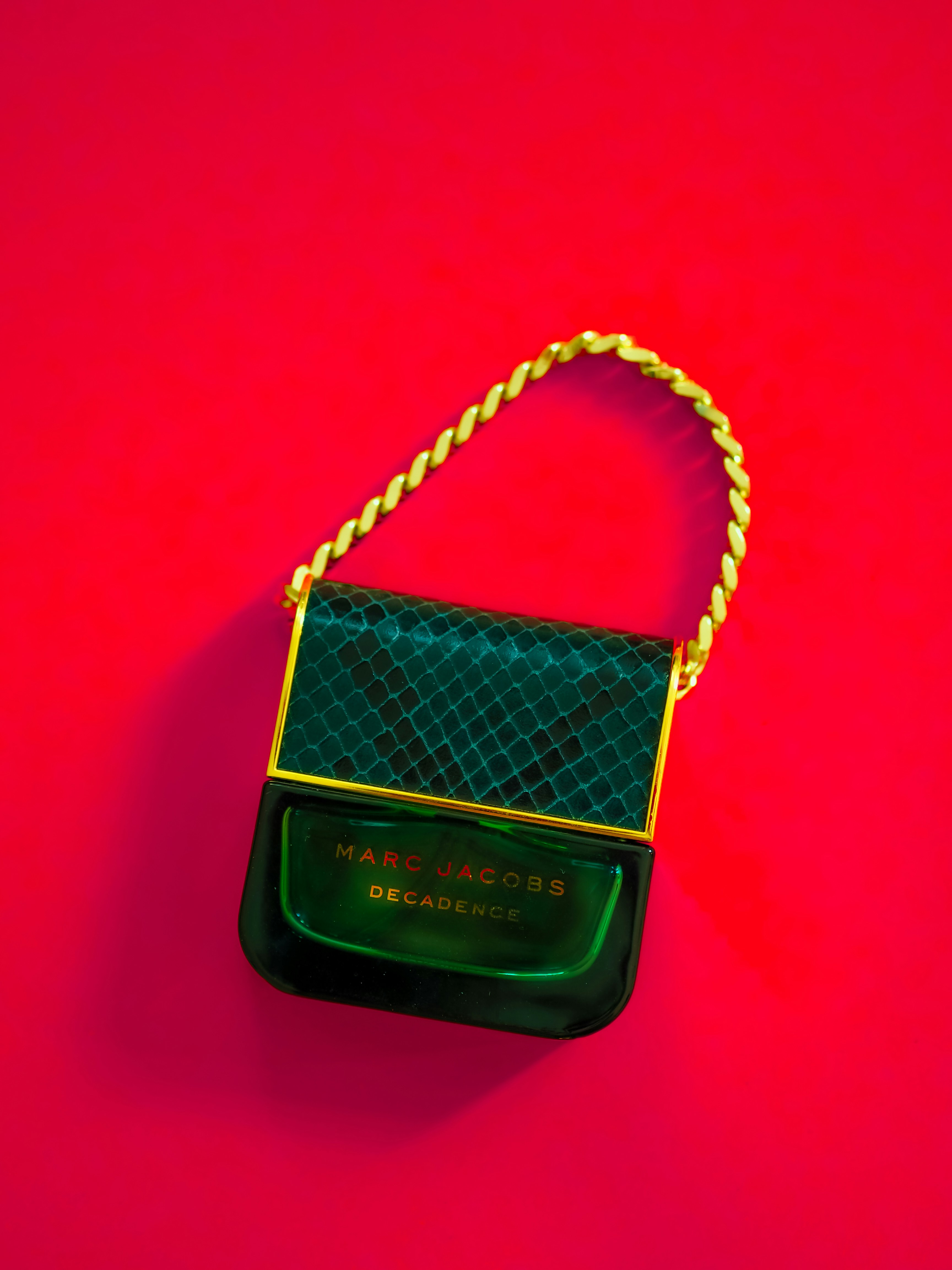 Crimson Backdrop, Emerald Decadence: A Gold-Chain Luxury in Focus