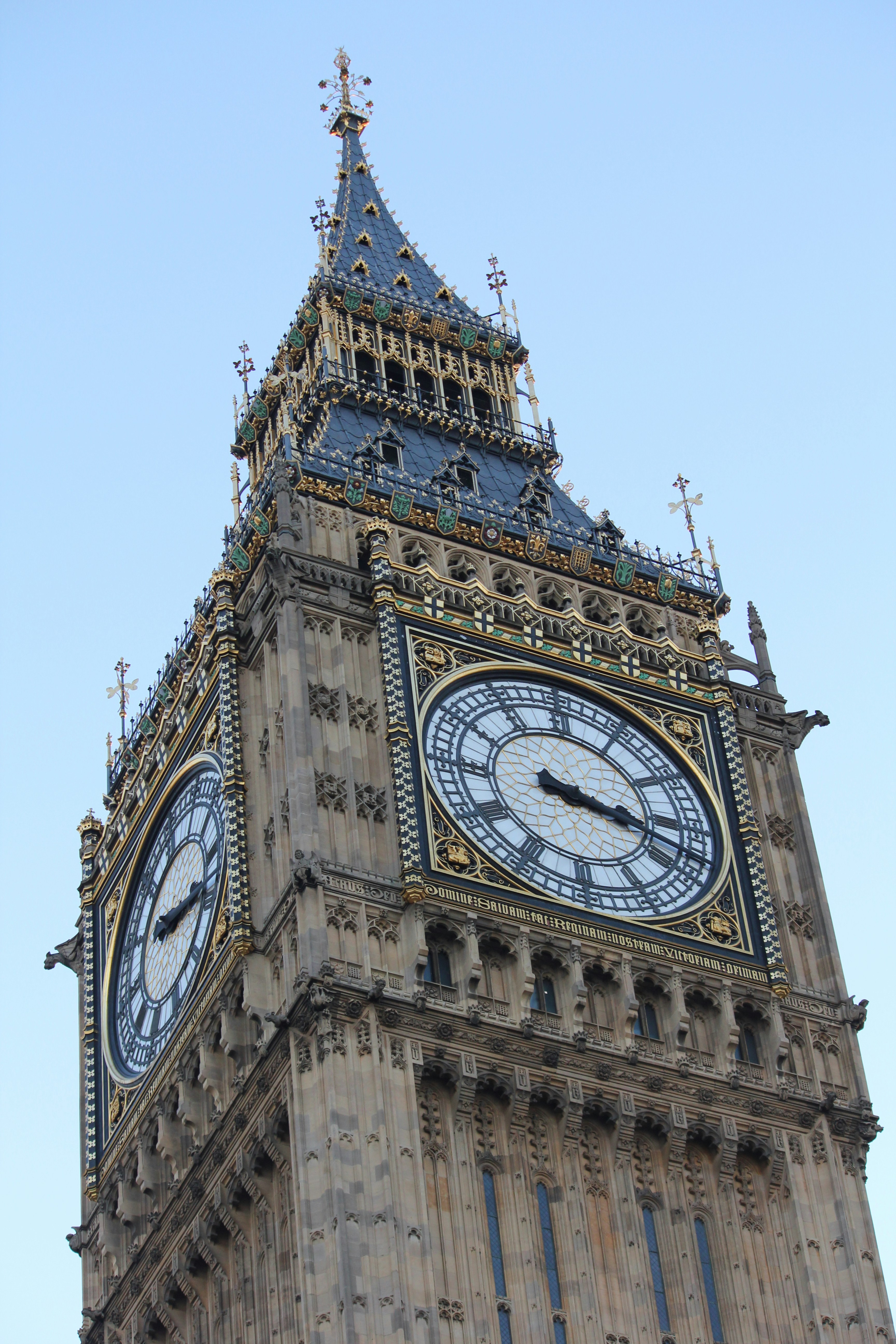 Iconic clock tower adorned with intricate details and vibrant colors against a clear blue sky.