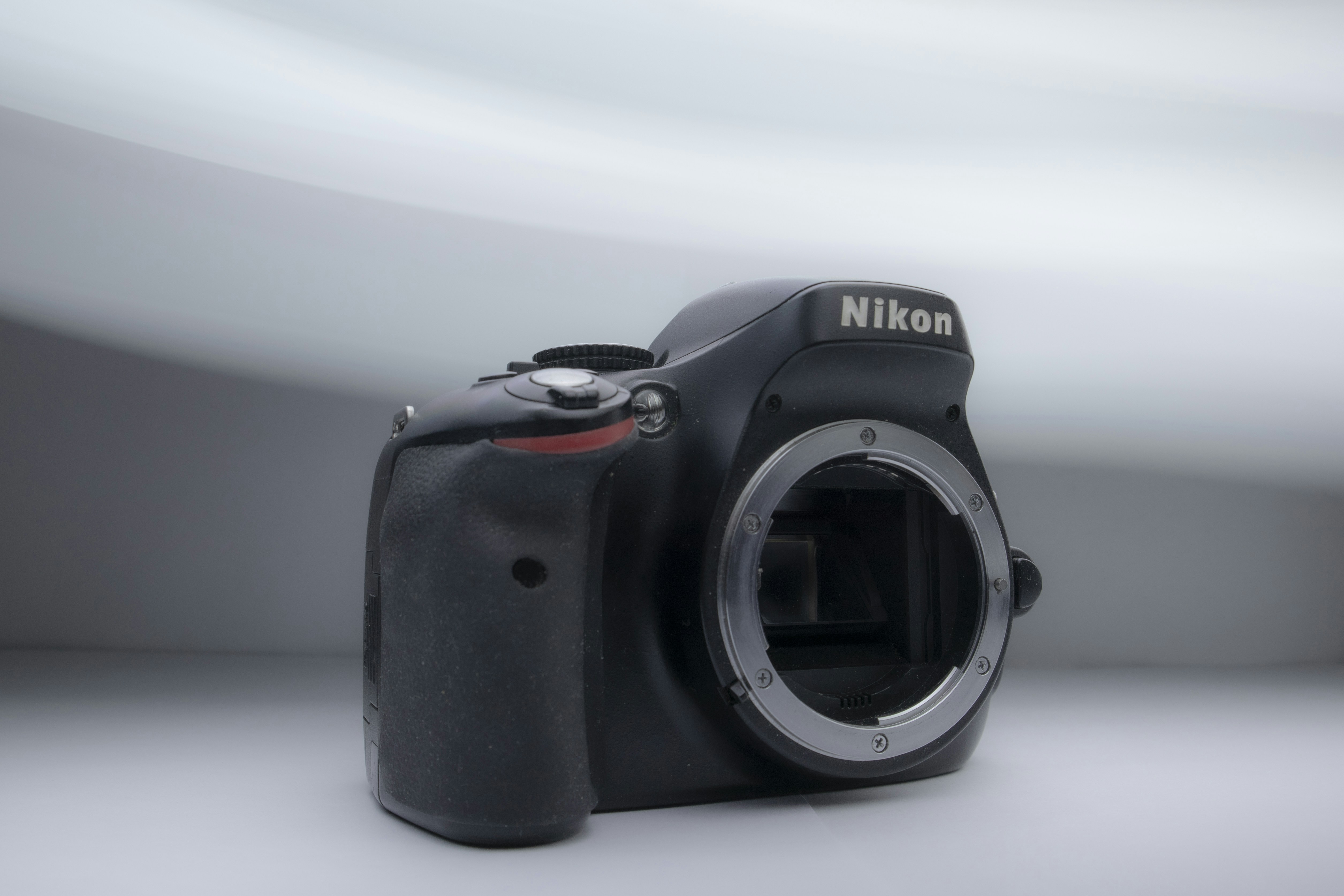 black nikon dslr camera on white surface