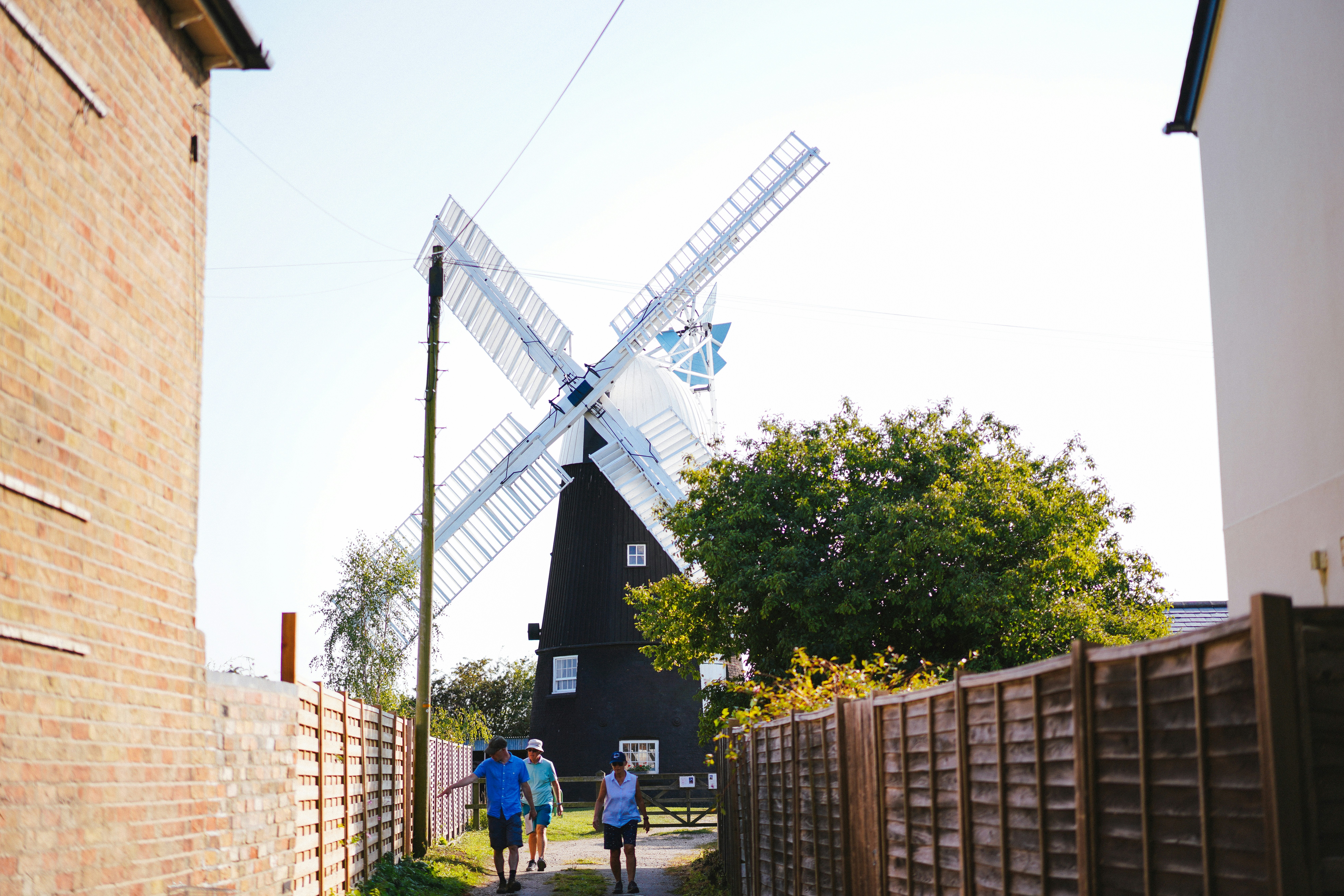 Windmill Lane: a sunlit village path toward the blades