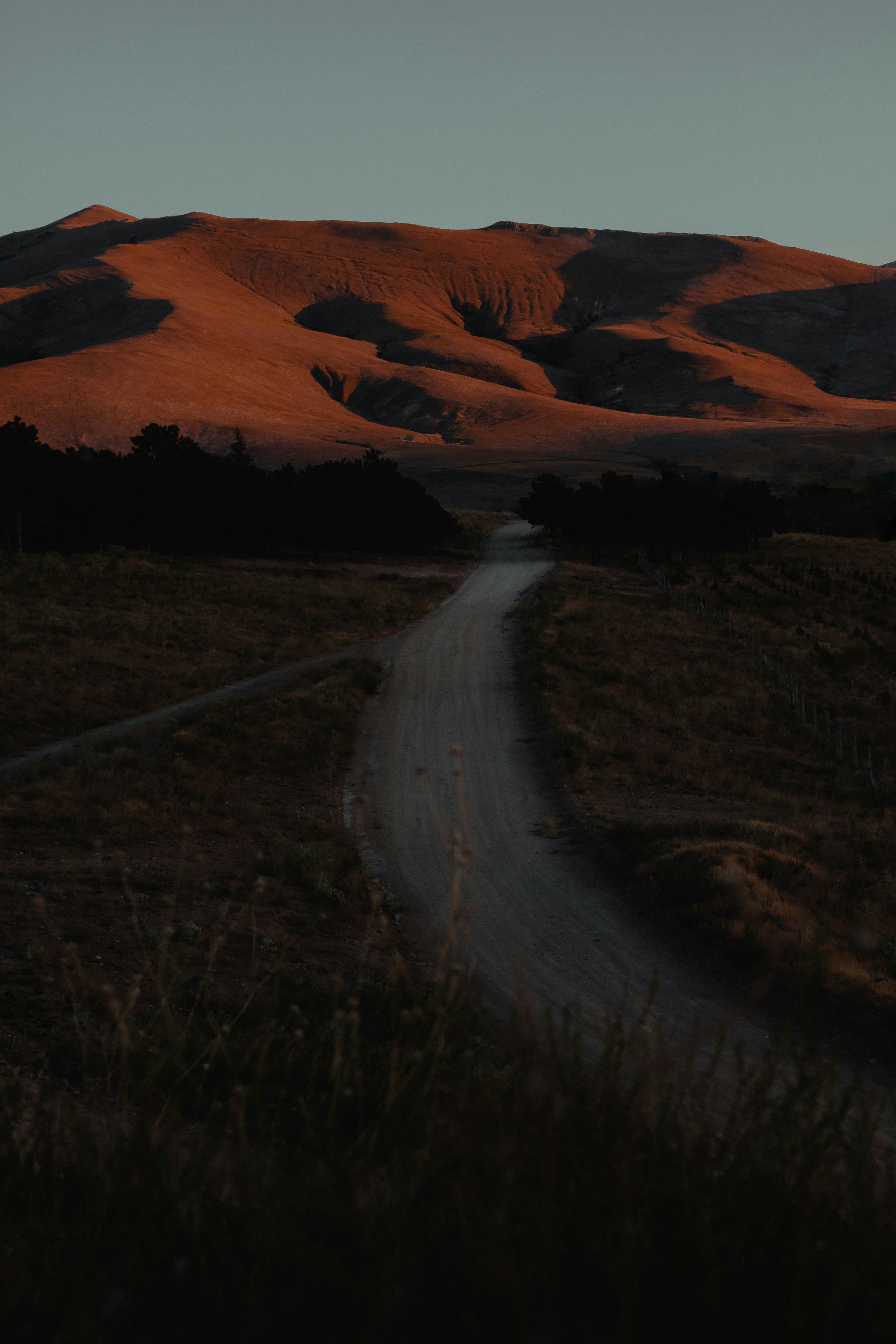 Dusk on the Dirt Road: Sunlit Ridge Unfolds Over a Quiet Valley