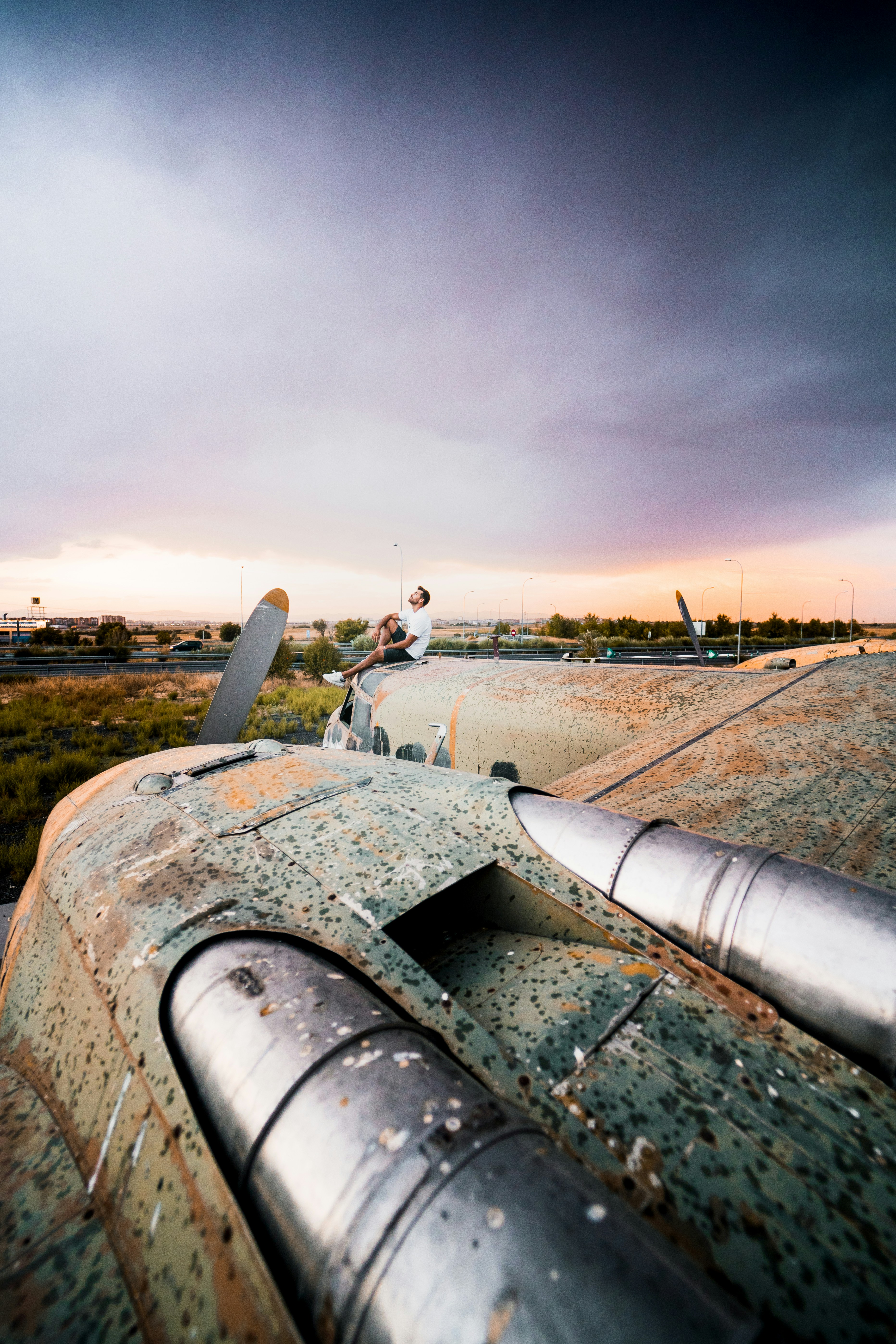 Perched on the Rusted Giant: climber atop a weathered aircraft at golden hour