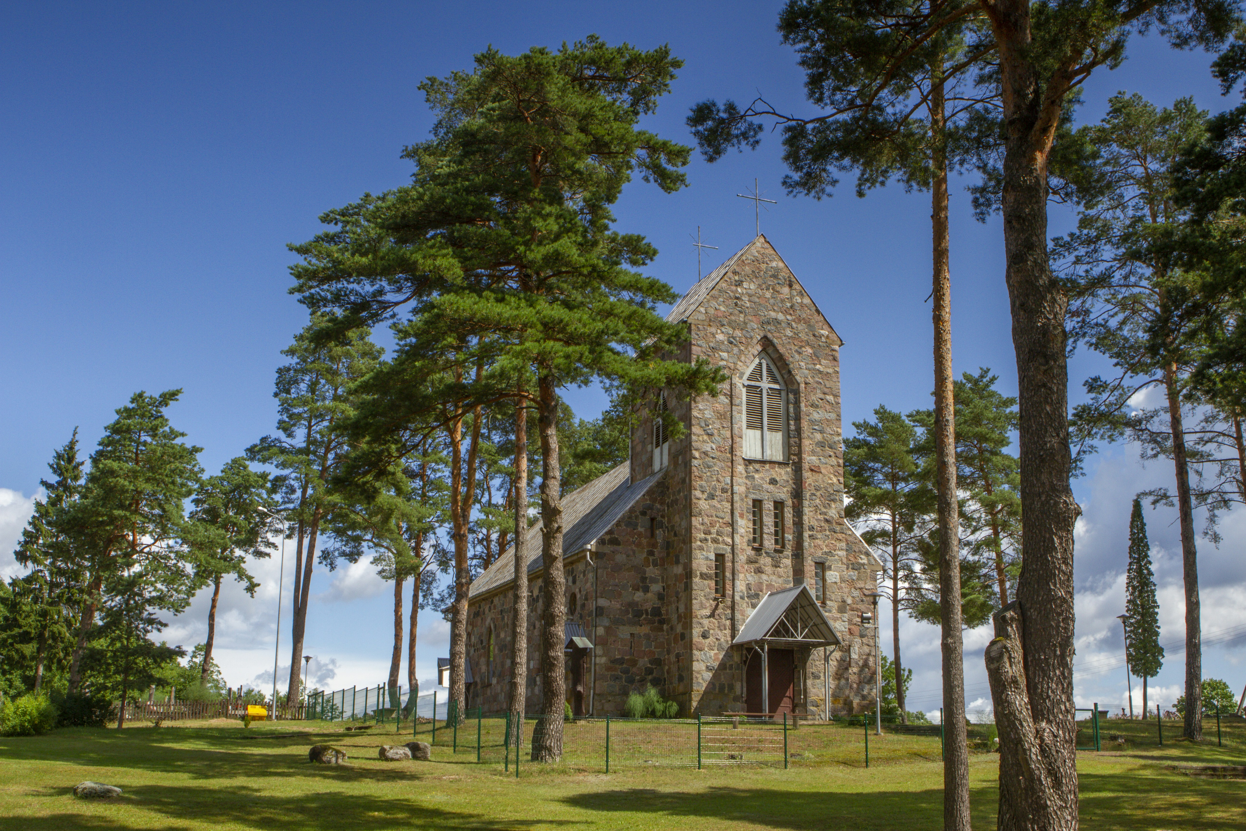 Pine-Framed Stone Chapel Under a Clear Blue Sky