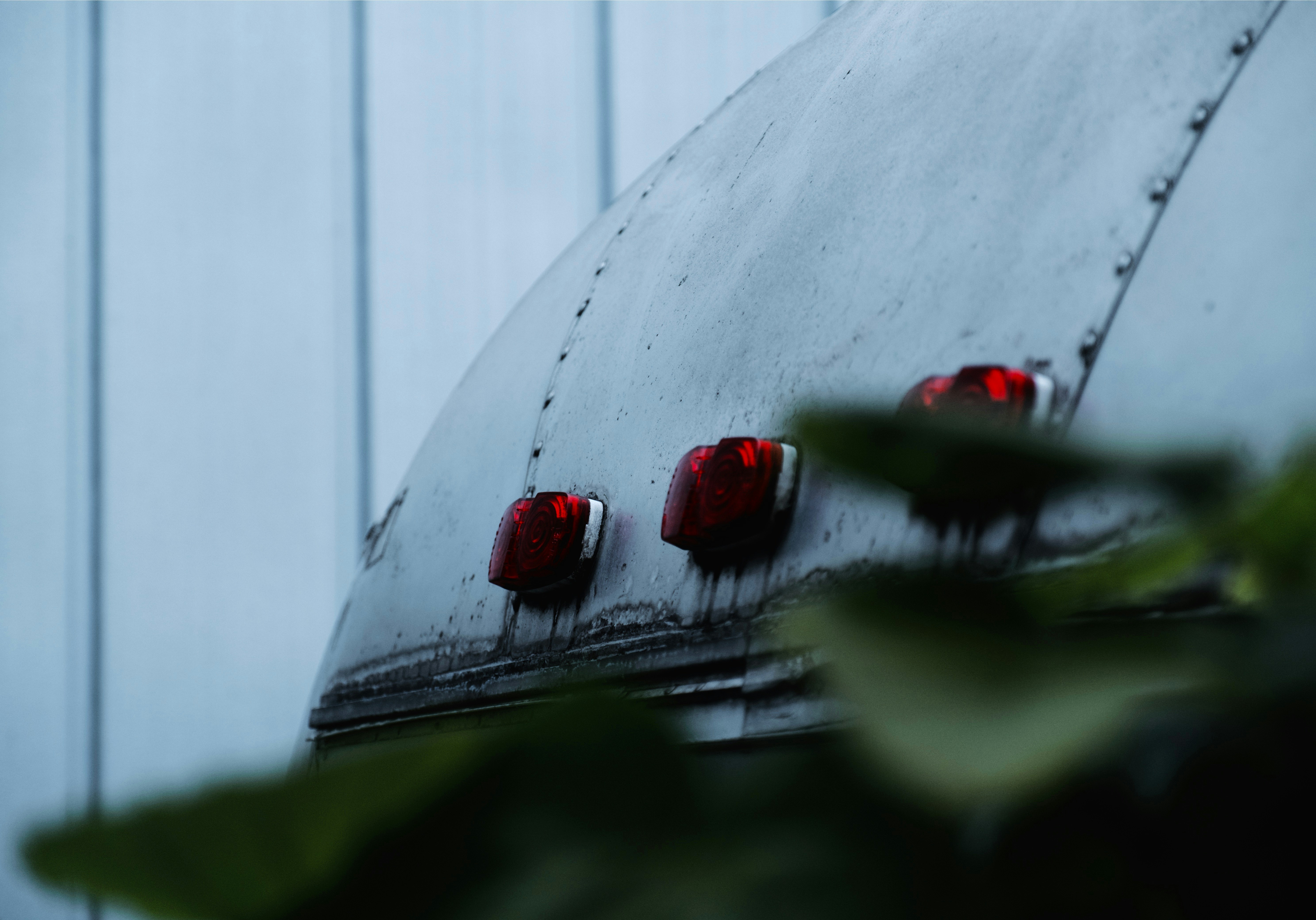 Three Red Lenses on a Weathered Steel Curve