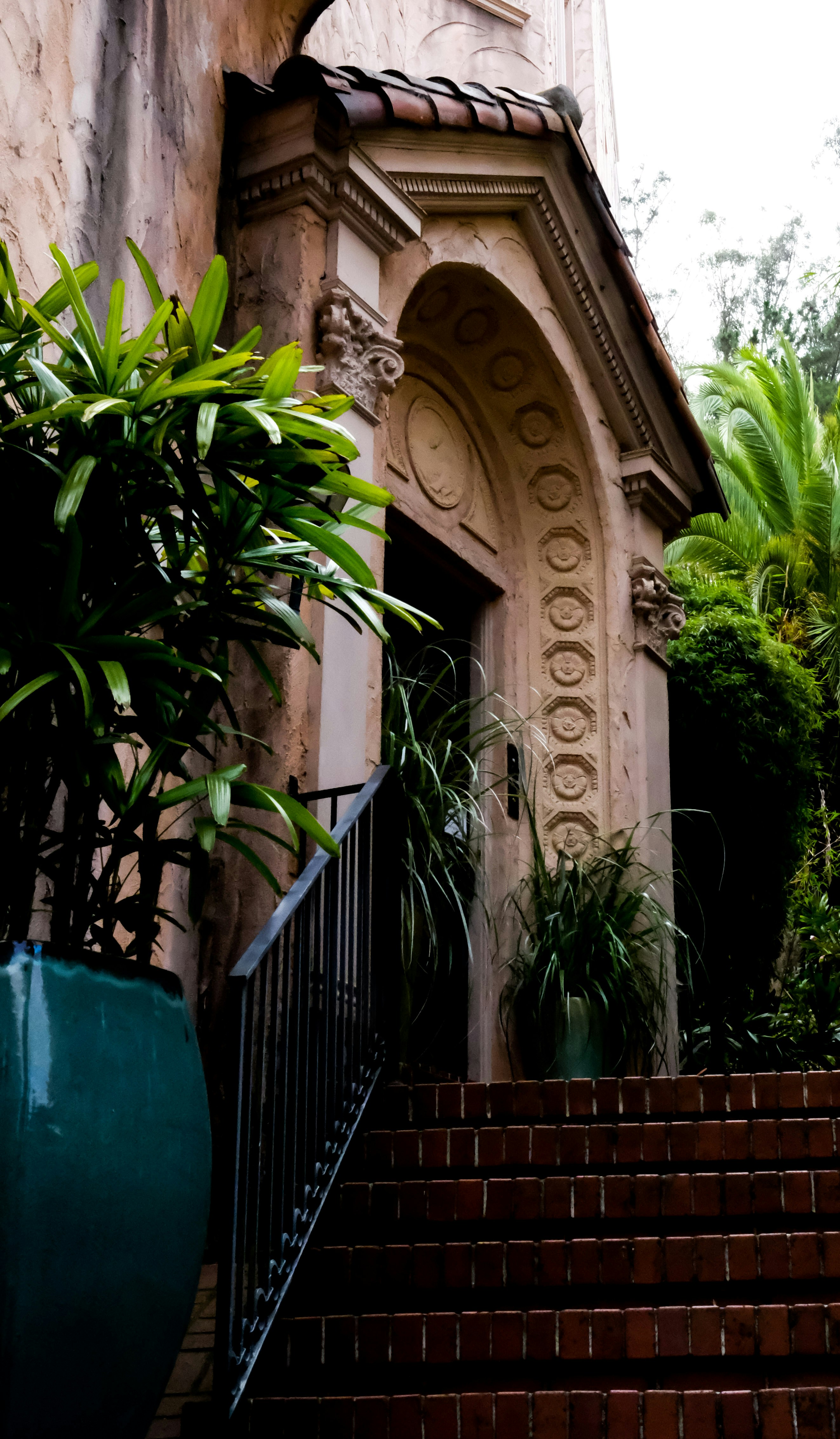 Carved Archway with Circular Motifs, Framed by Tropical Foliage
