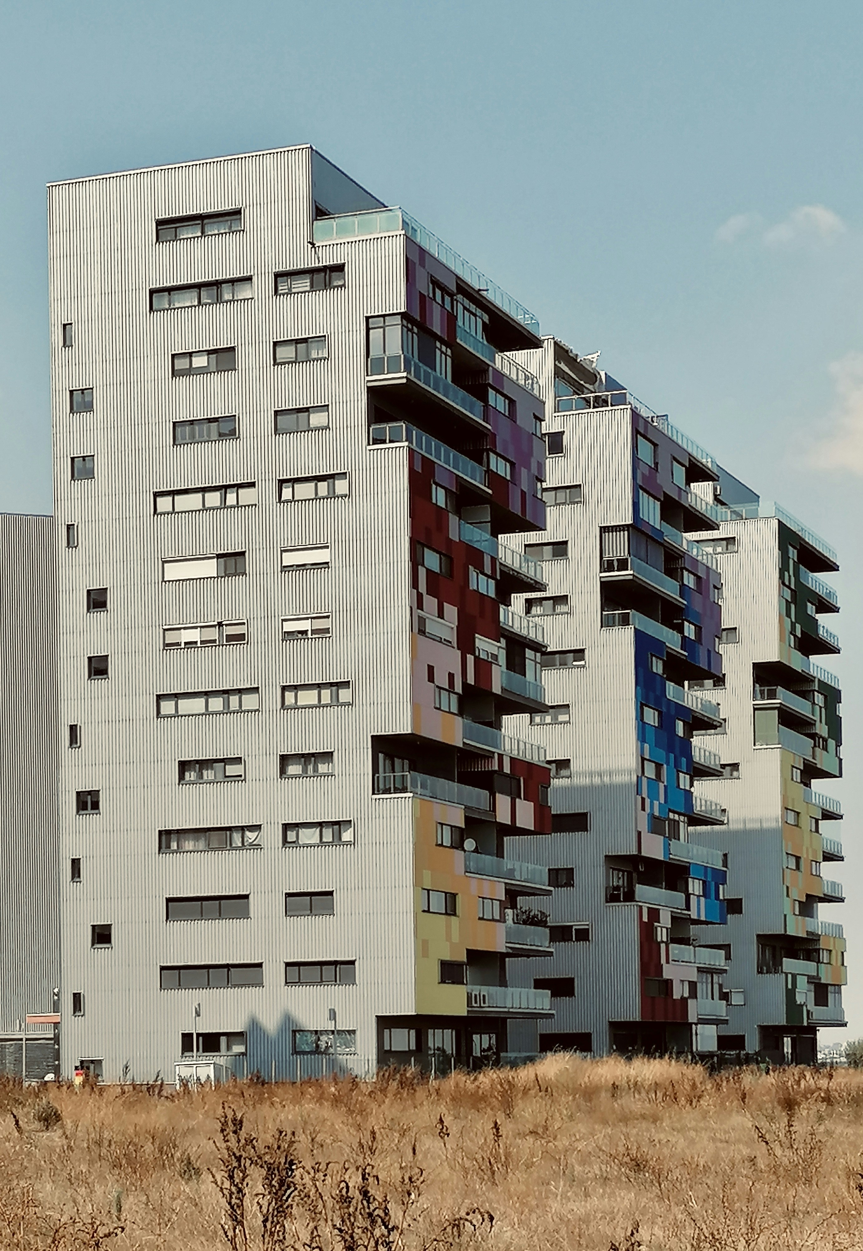 Colorful modern apartment building showcasing a unique facade with geometric patterns and balconies.