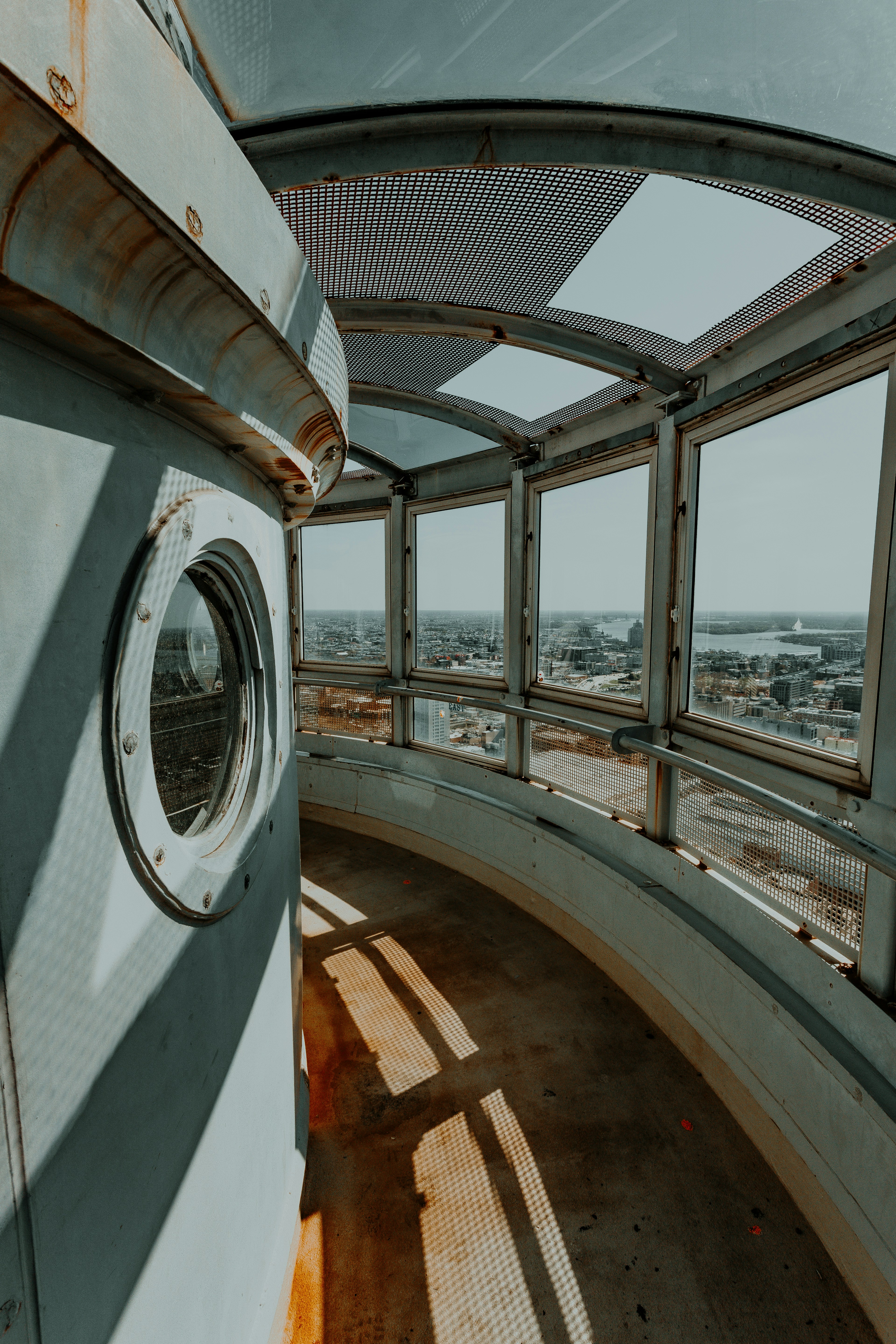 Porthole Overlook: Rusted Circular Frame Over the City