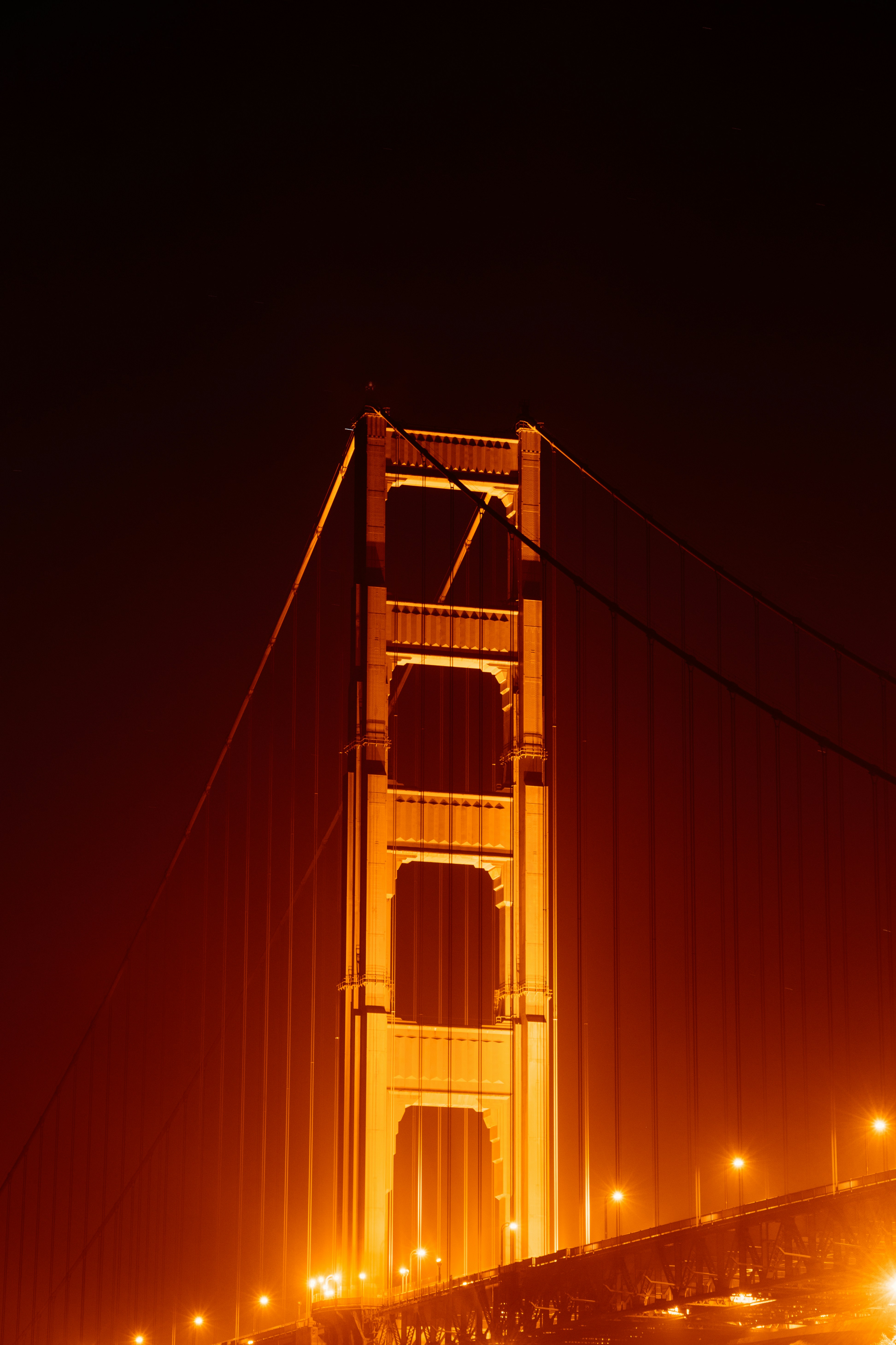 Amber Beacon: the Golden Gate Bridge Tower in Night’s Fog