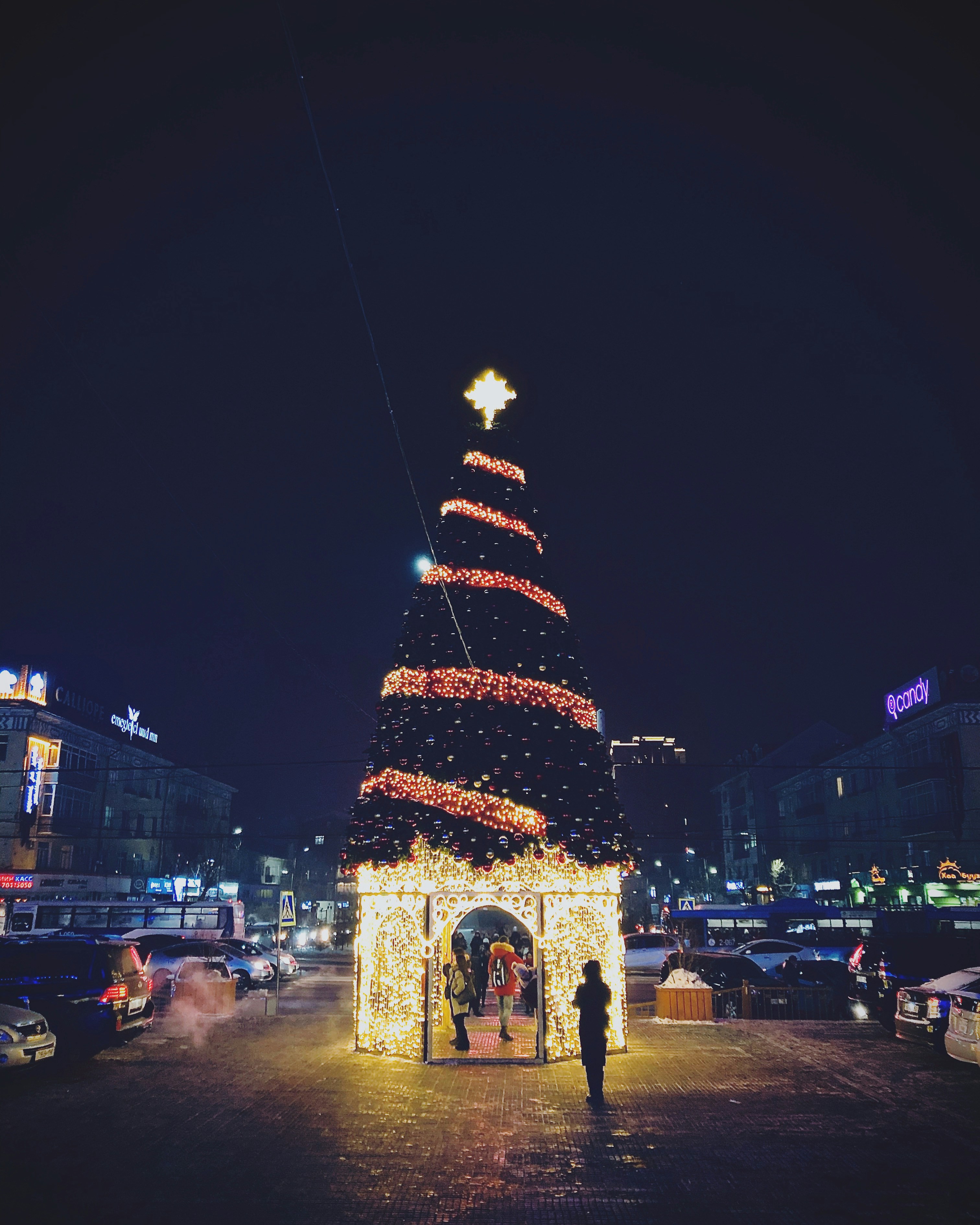 Swirl of Lights: Night-Topped Christmas Tree Anchors a Bustling City Square