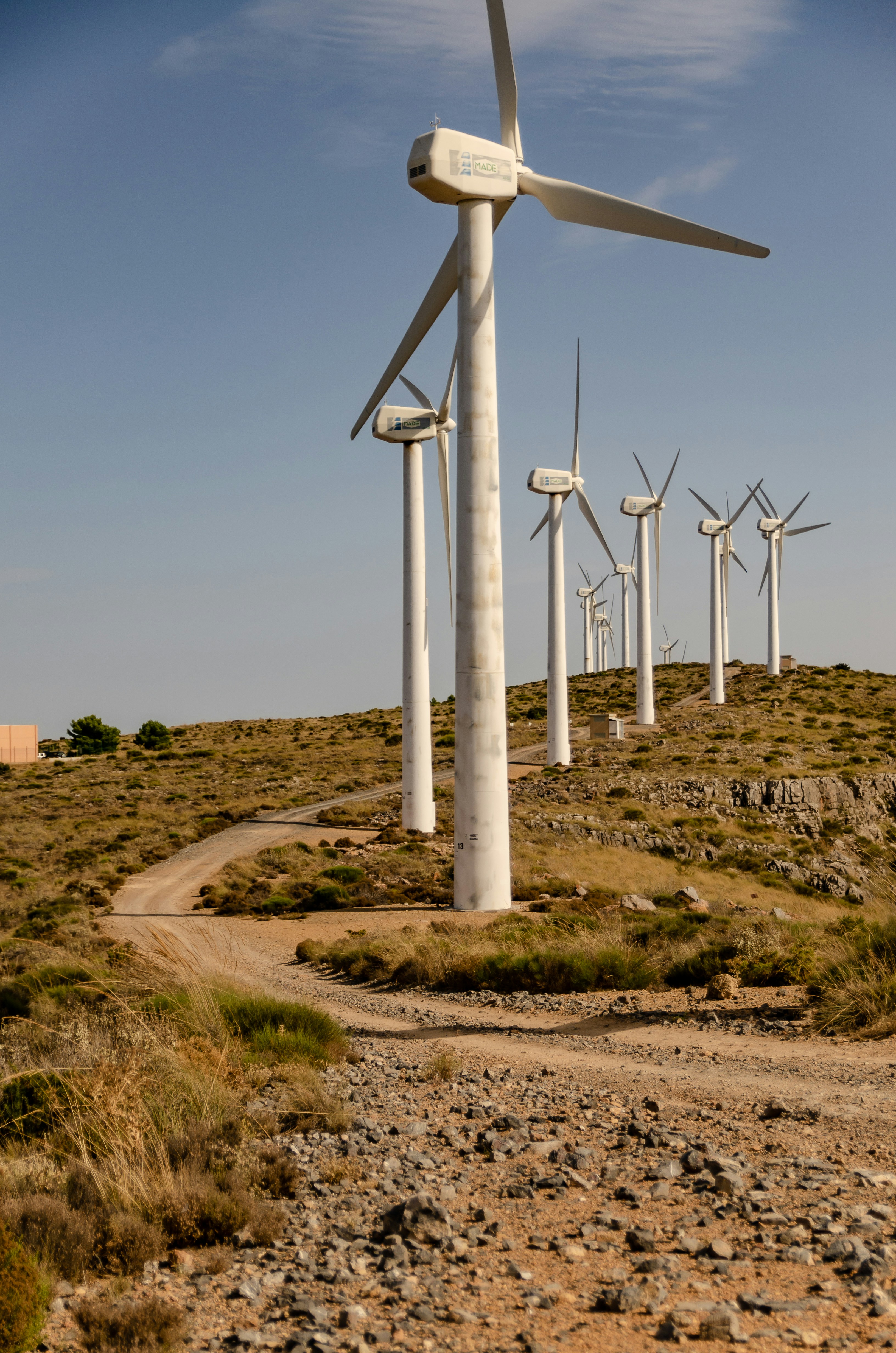White wind turbines on brown field under blue sky during daytime photo ...