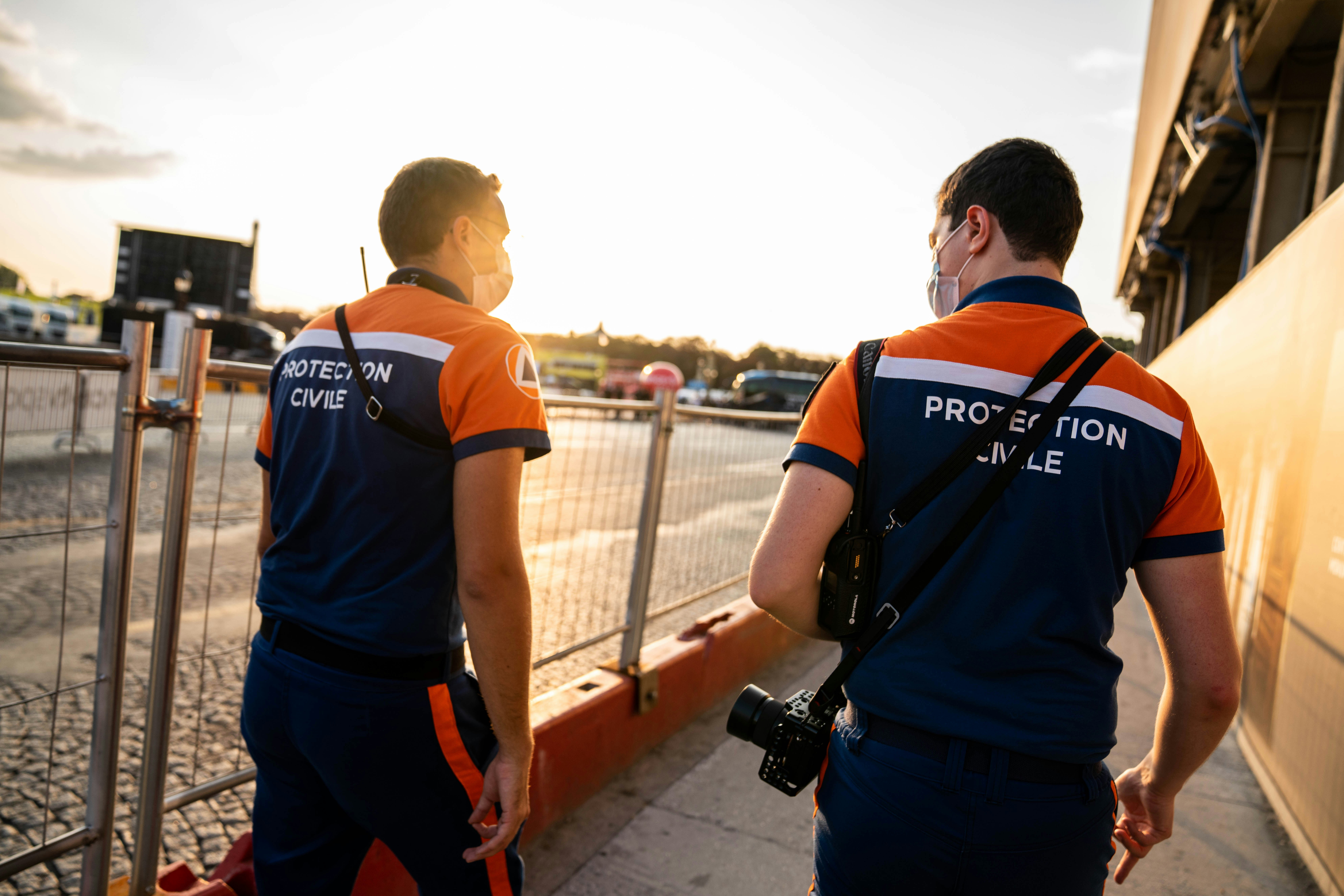 Two members of the Protection Civile walking towards the sunset, showcasing their commitment to safety and service.