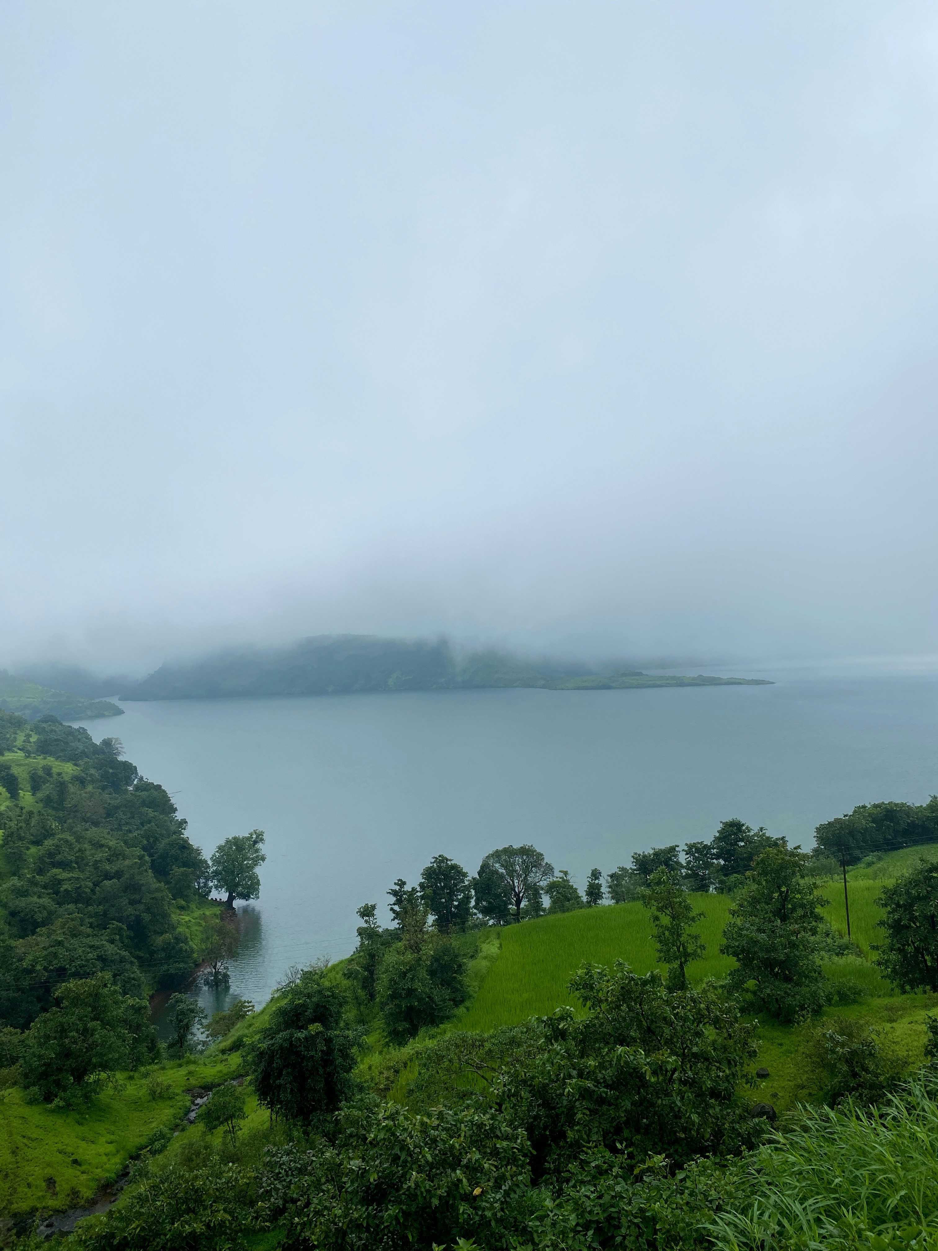 Mist over Emerald Slopes by a Quiet Lake