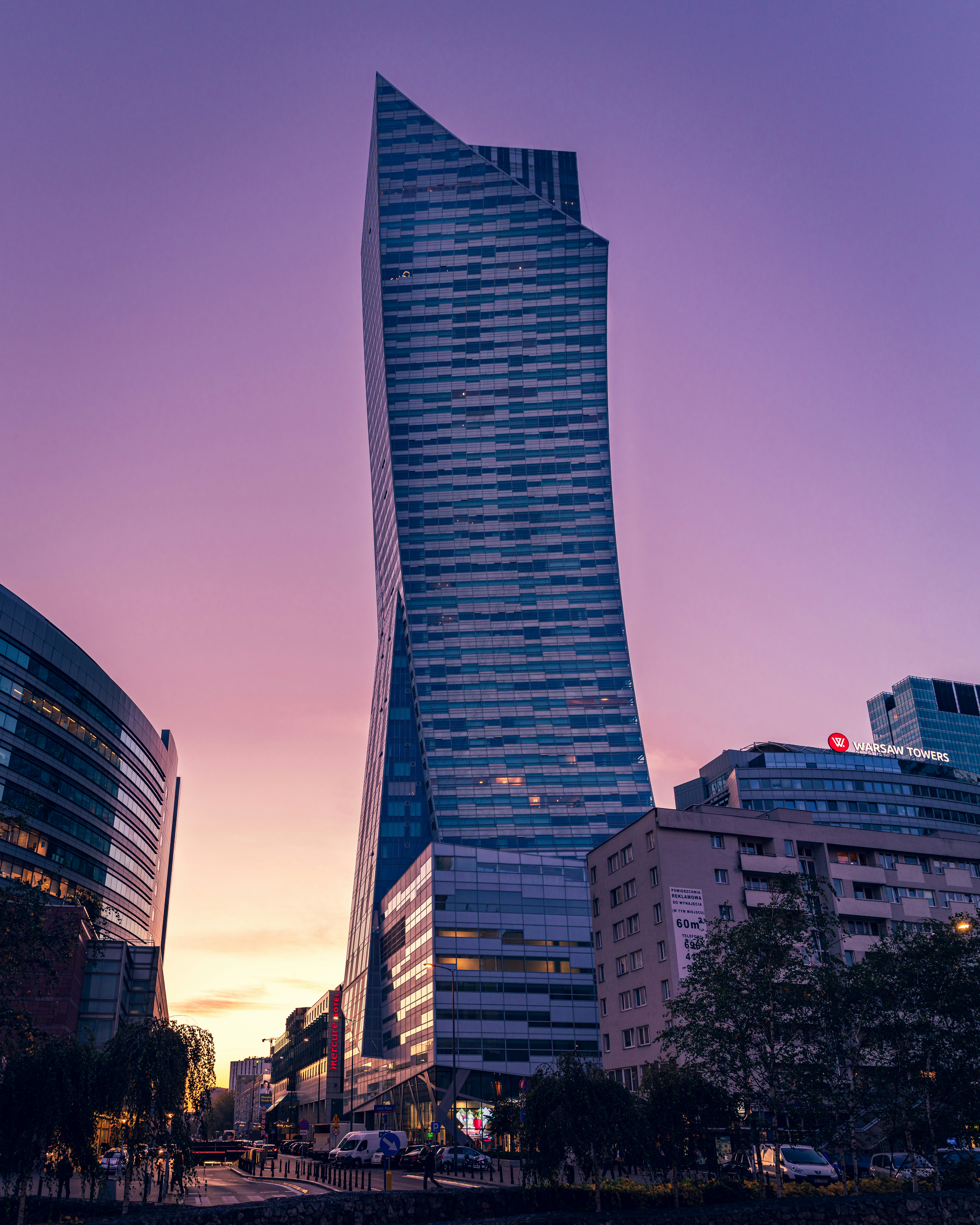 Twisted Apex at Dusk: Sunset Illuminates a Leaning Glass Tower