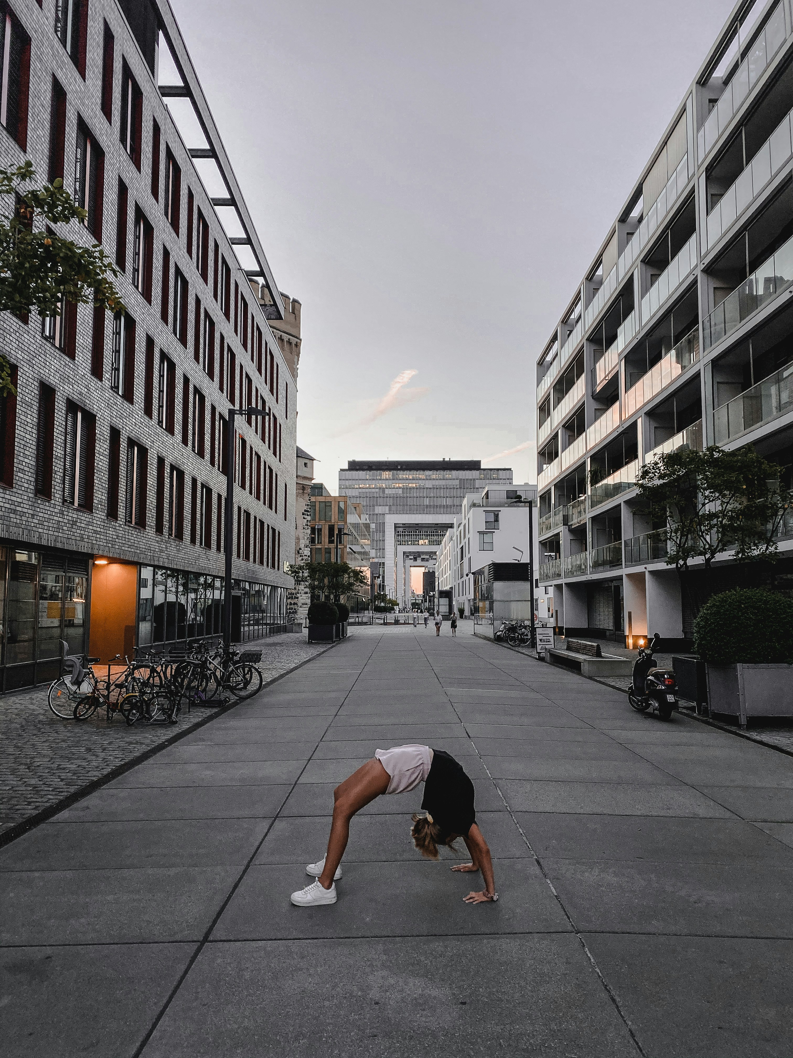 Backbend at the Boulevard: A Solitary Pose Amid Modern Geometry