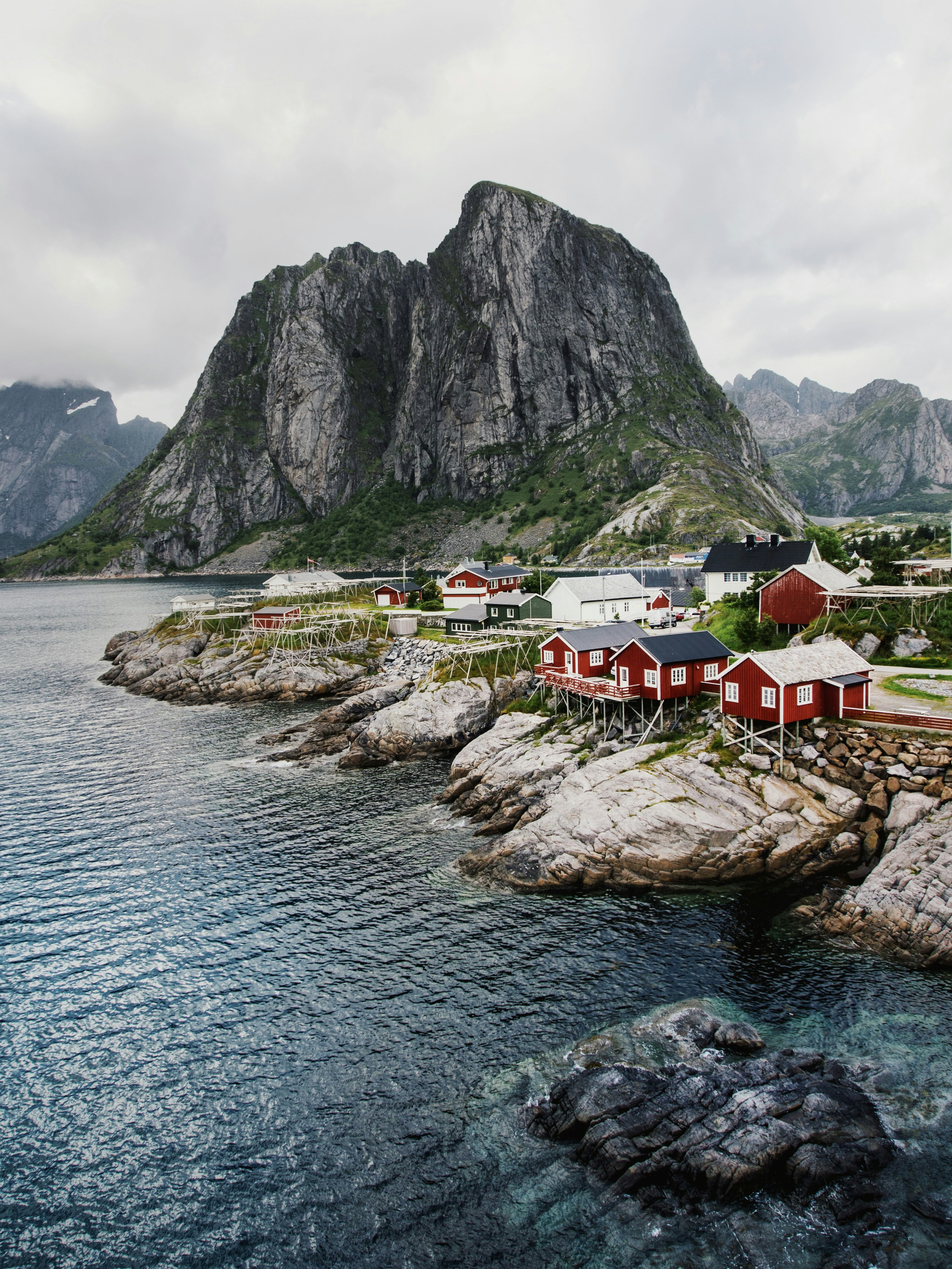 A small fishing village at Lofoten Islands in Norway. | houses near body of water and mountain during daytime