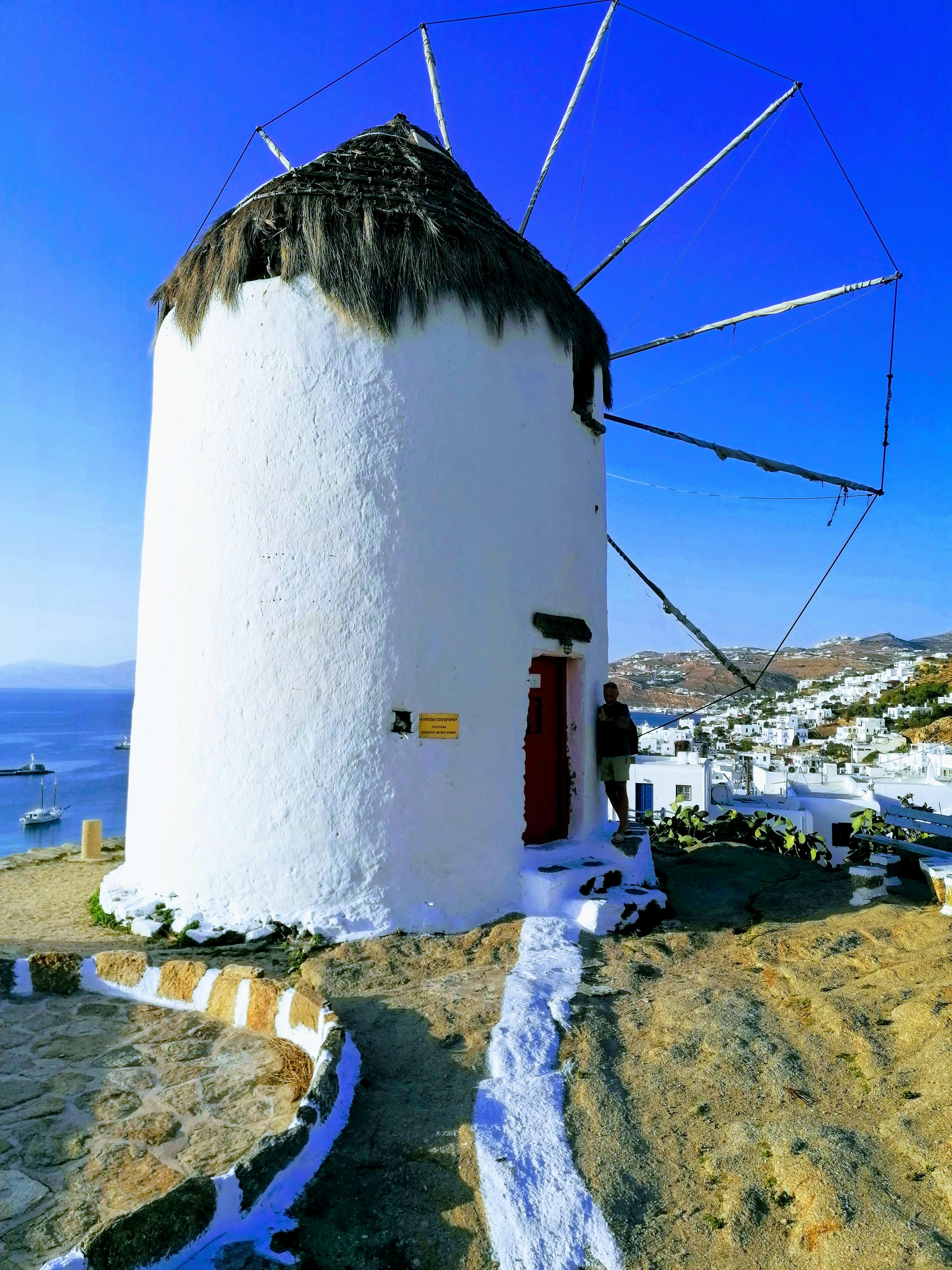 Cerulean Sky Over a White Windmill: Cliffside Tranquility
