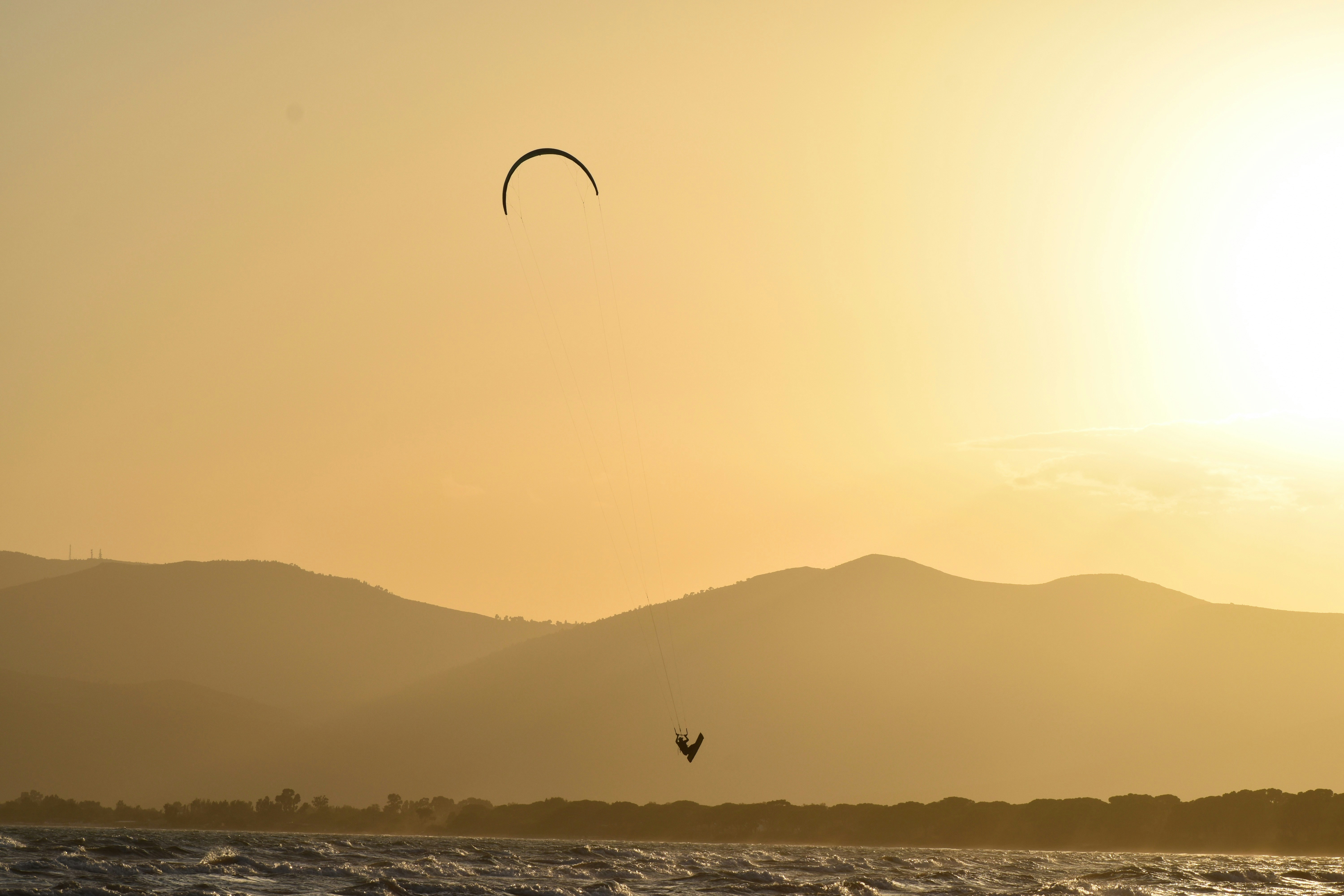 Luminous Horizon: Paraglider Silhouette Against Sunset