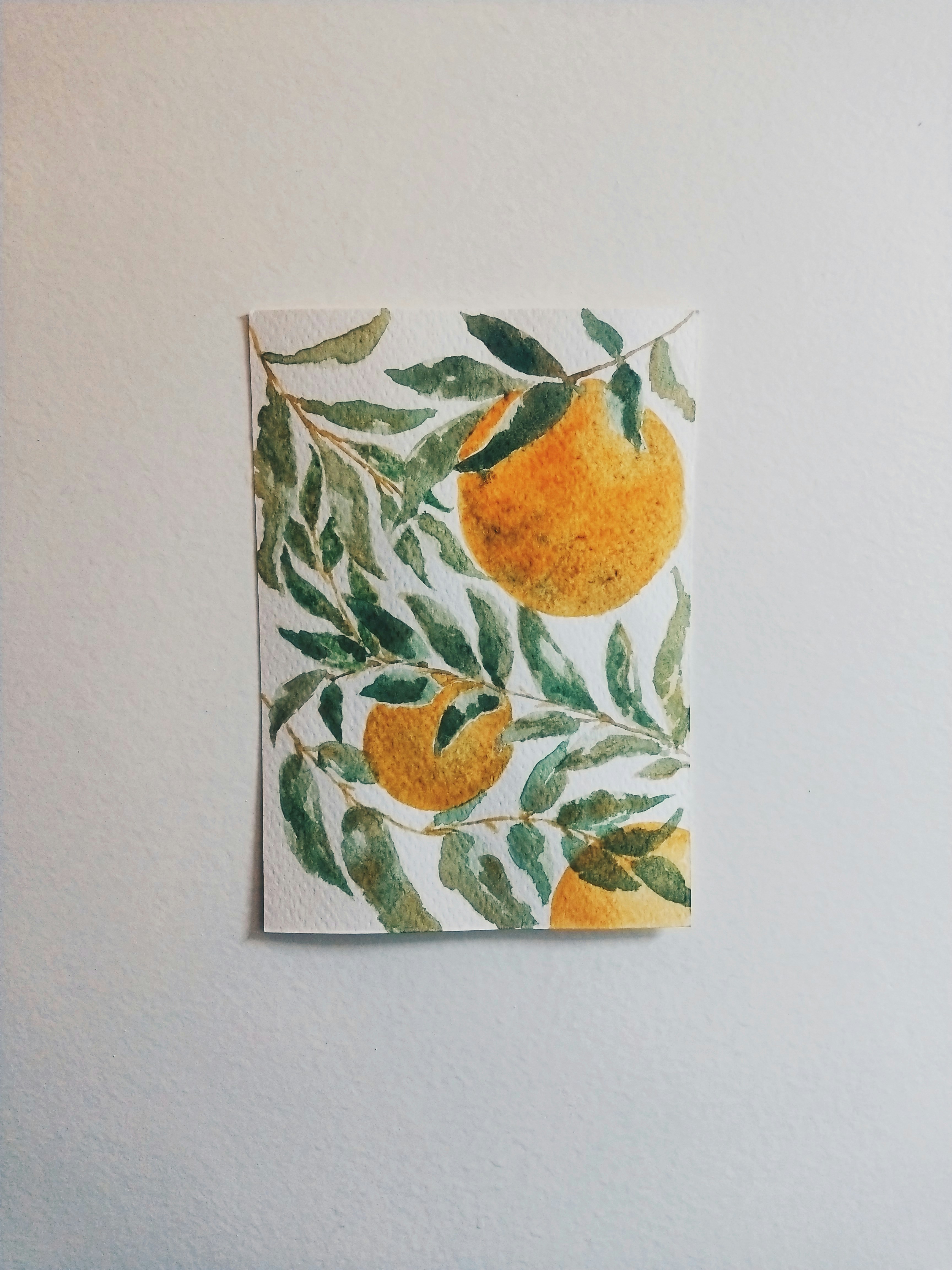 Watercolor illustration featuring vibrant oranges intertwined with lush green leaves on textured paper.