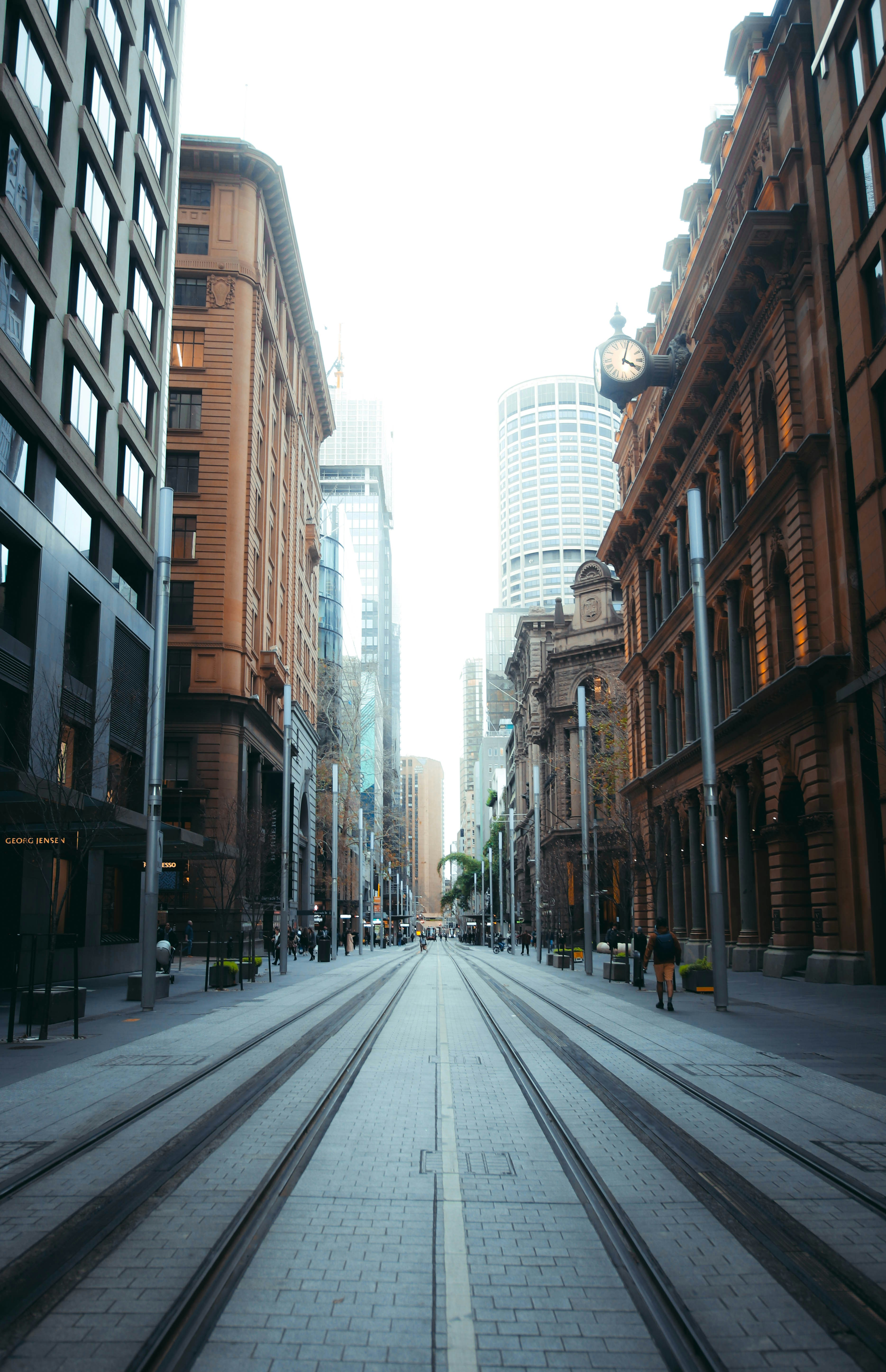 gray concrete road between high rise buildings during daytime