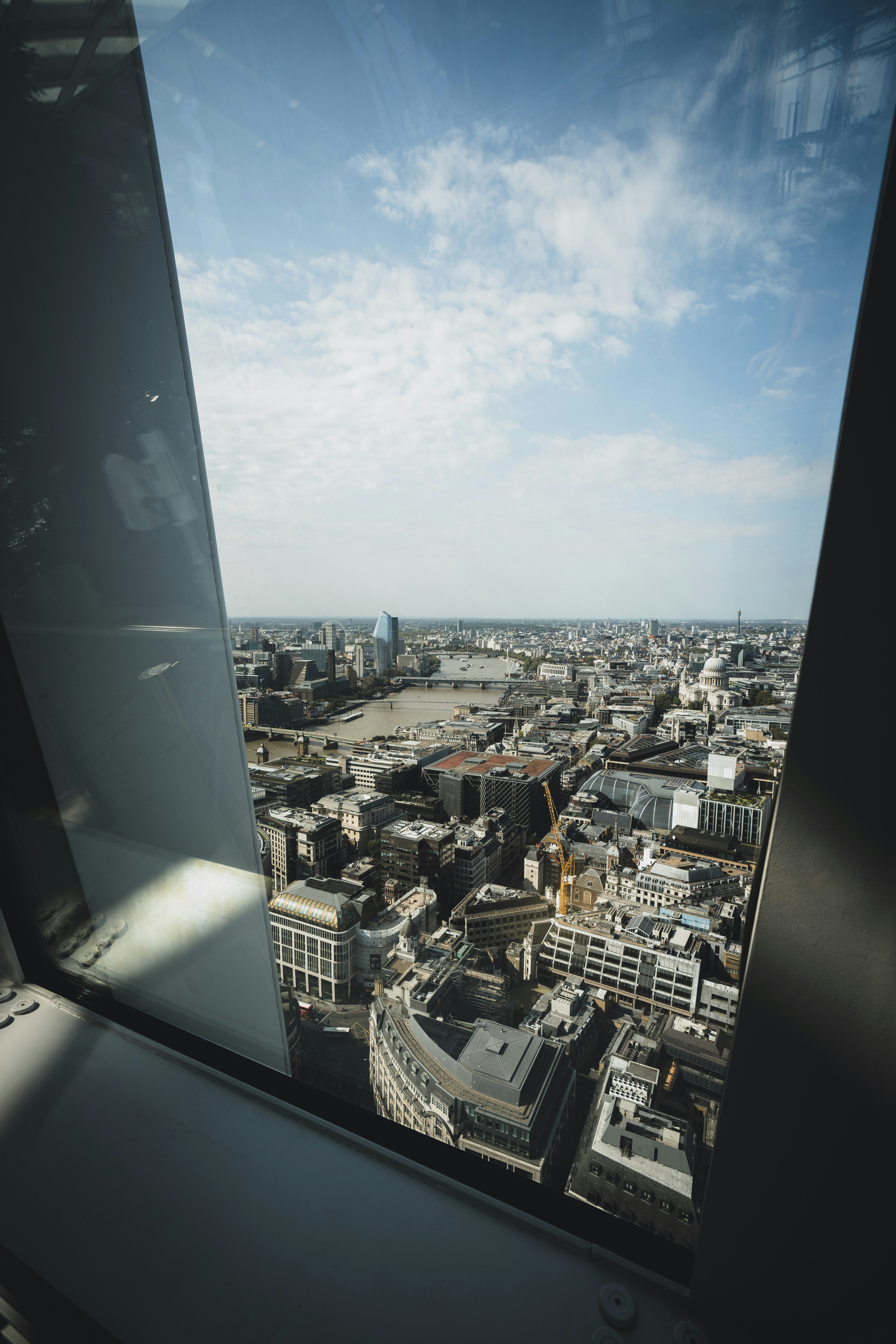 Aerial view of a bustling cityscape with the River Thames winding through, showcasing a mix of modern and historic architecture.