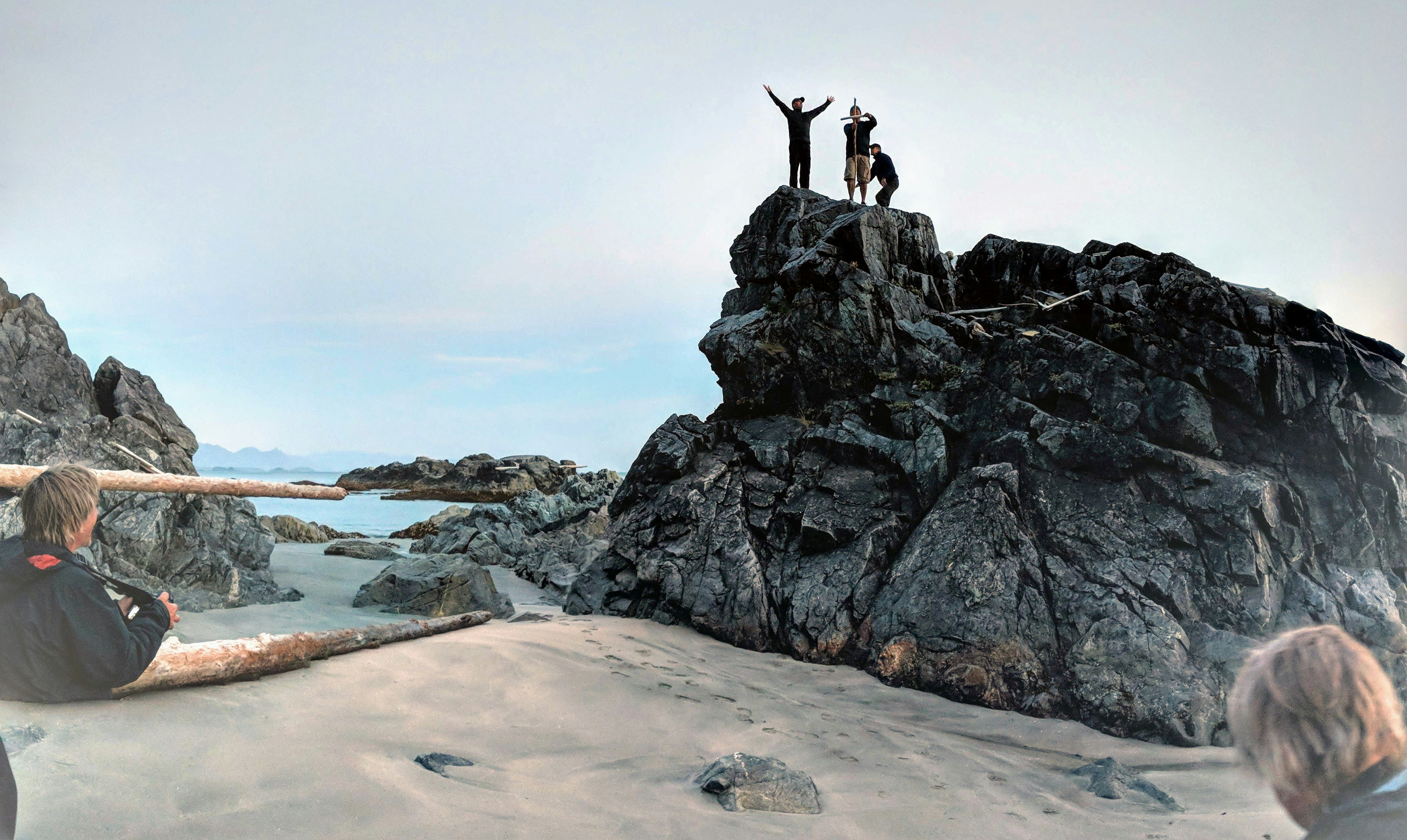 person standing on rock formation near sea during daytime