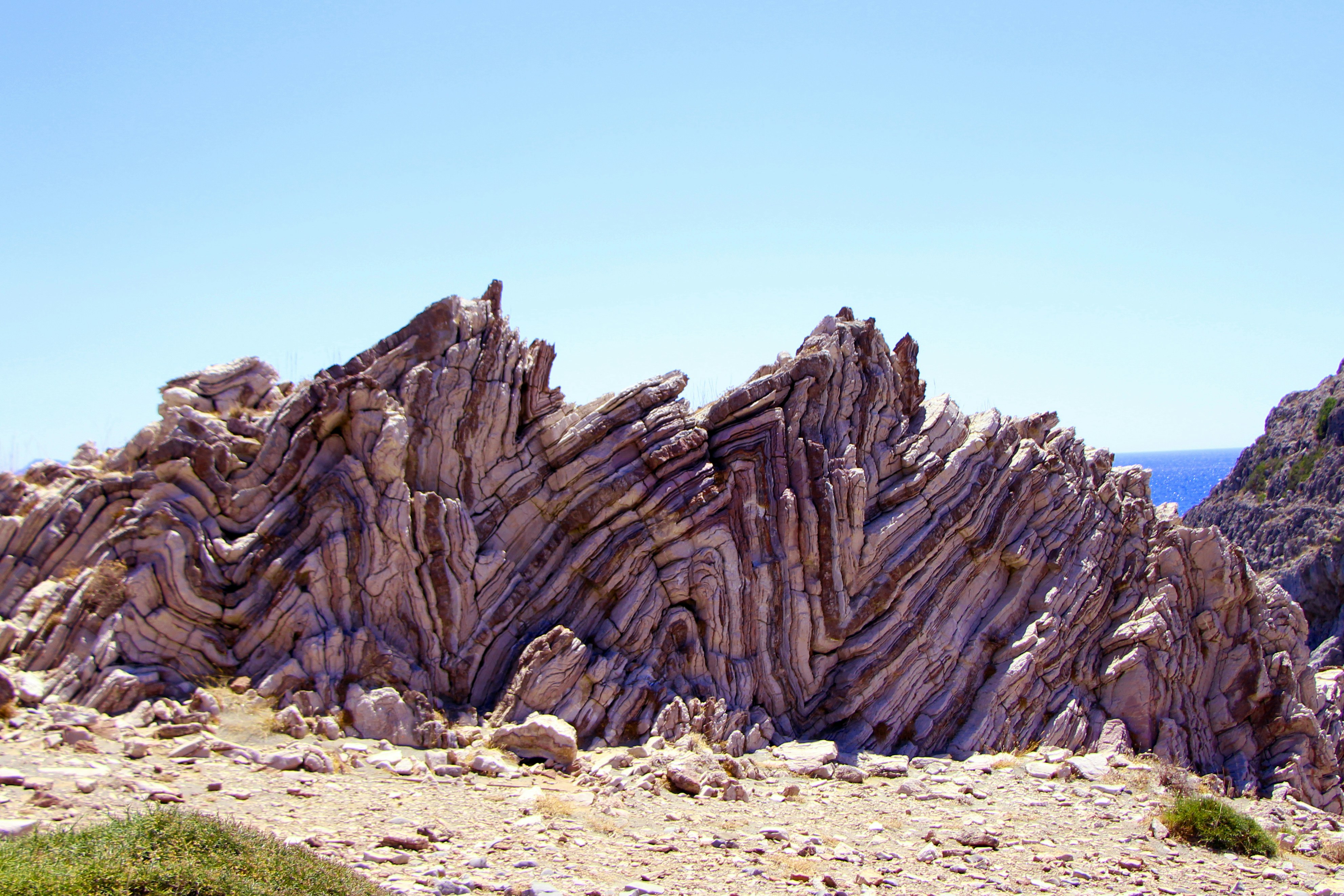 Flowering rock spires against a cobalt sea