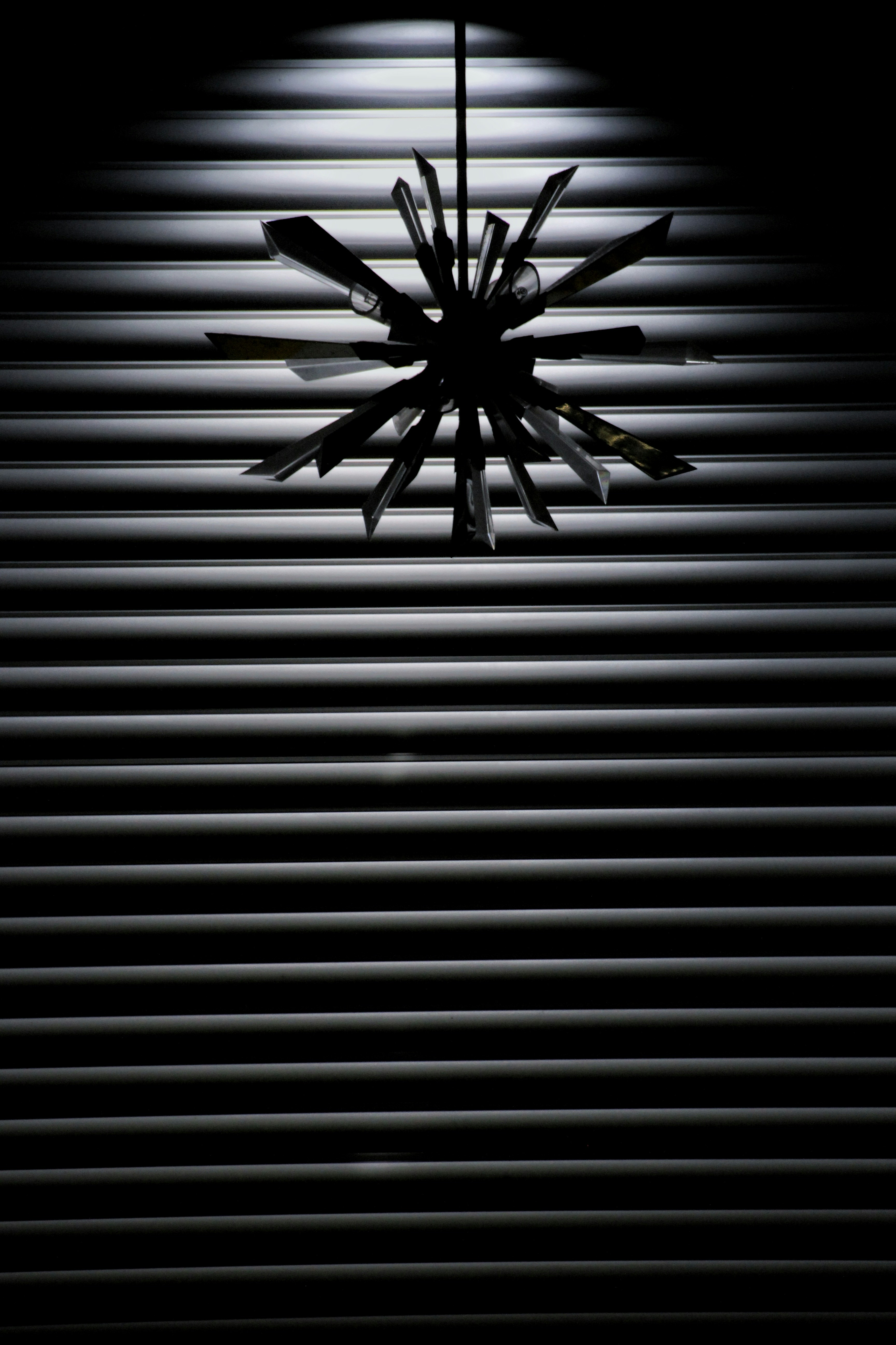 Radial Sunburst: A metallic starburst against horizontal blinds