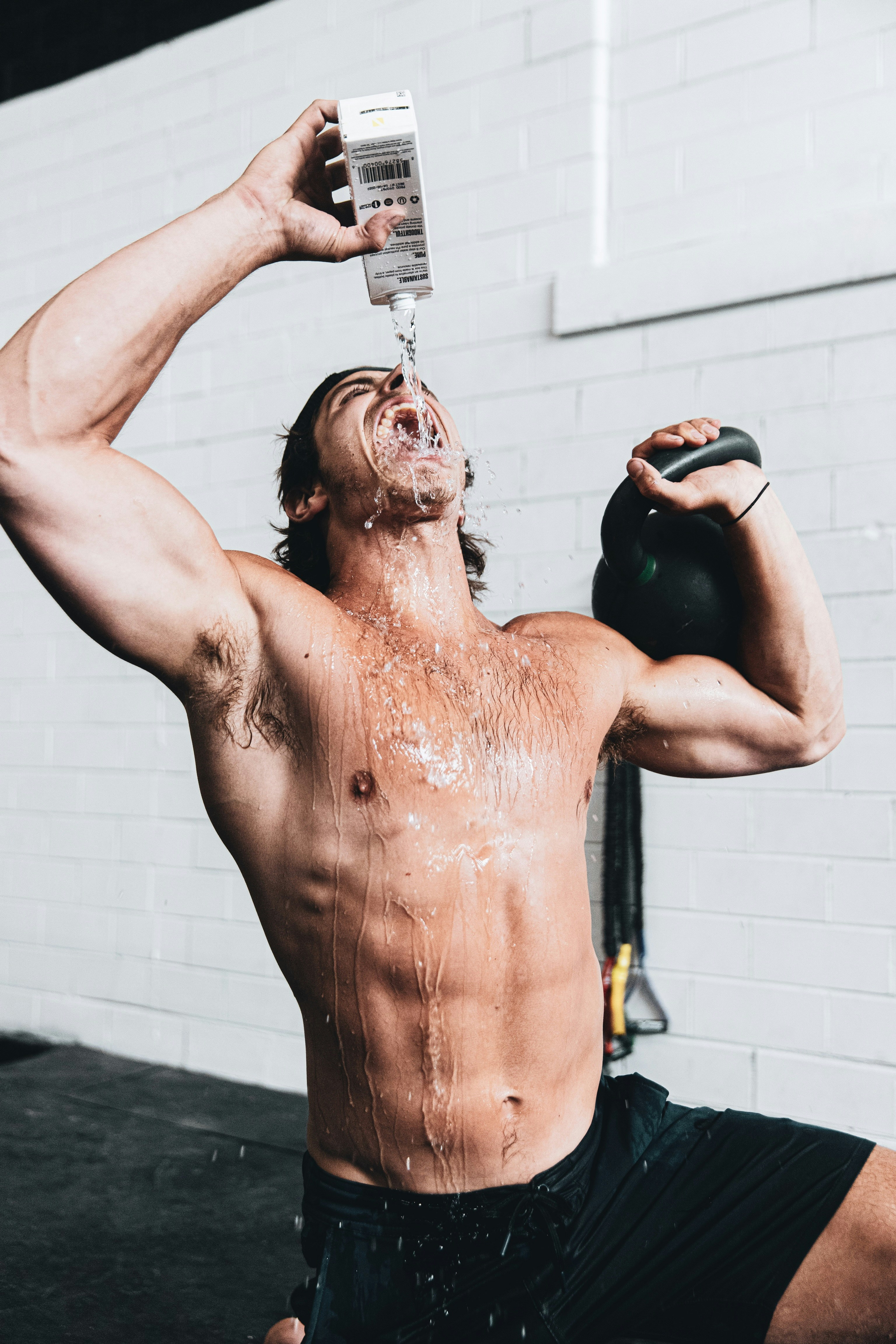 Hydration Punch: A Shirtless Refill in the Gym Lights