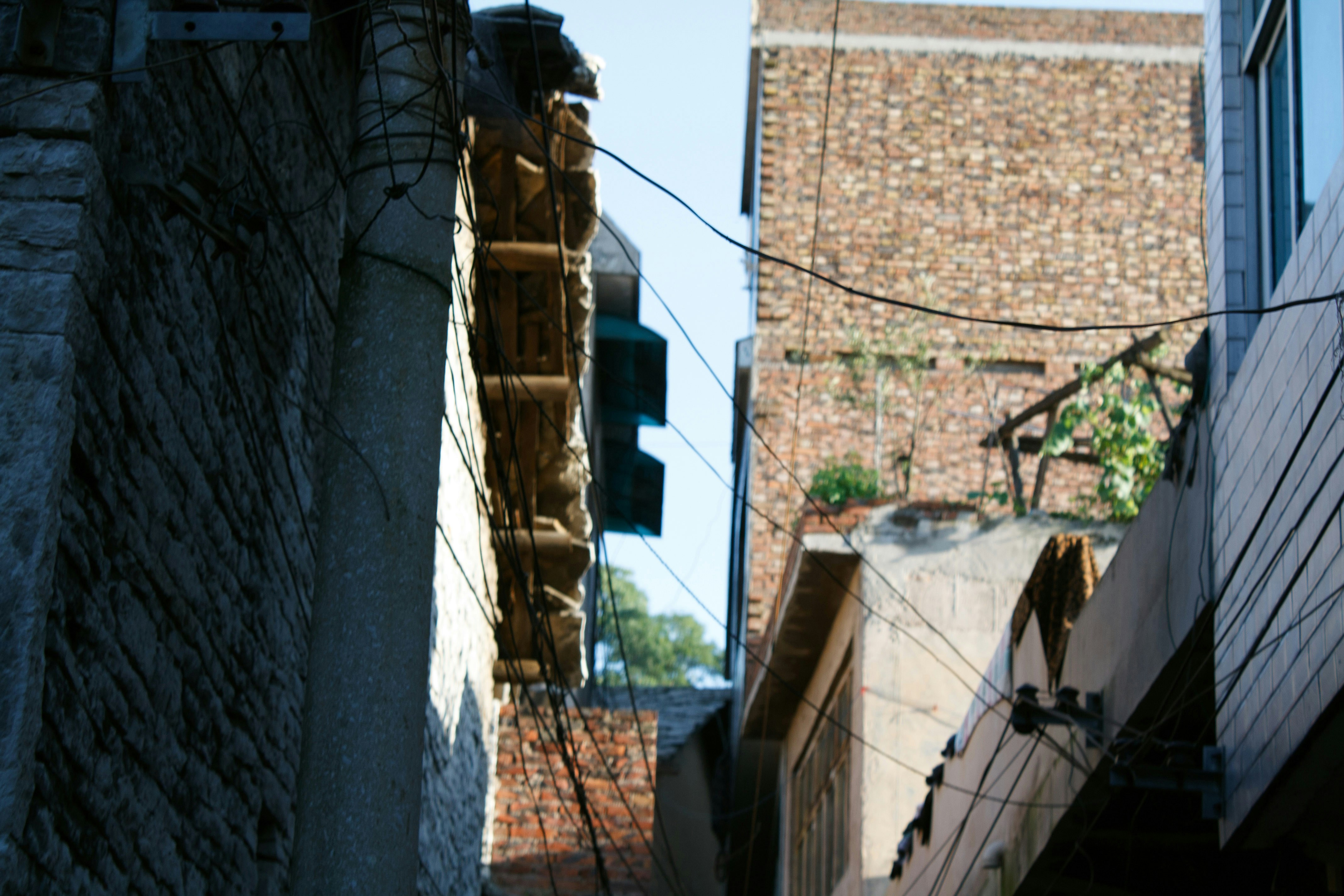 Sky Peeks Through a Narrow Brick Corridor