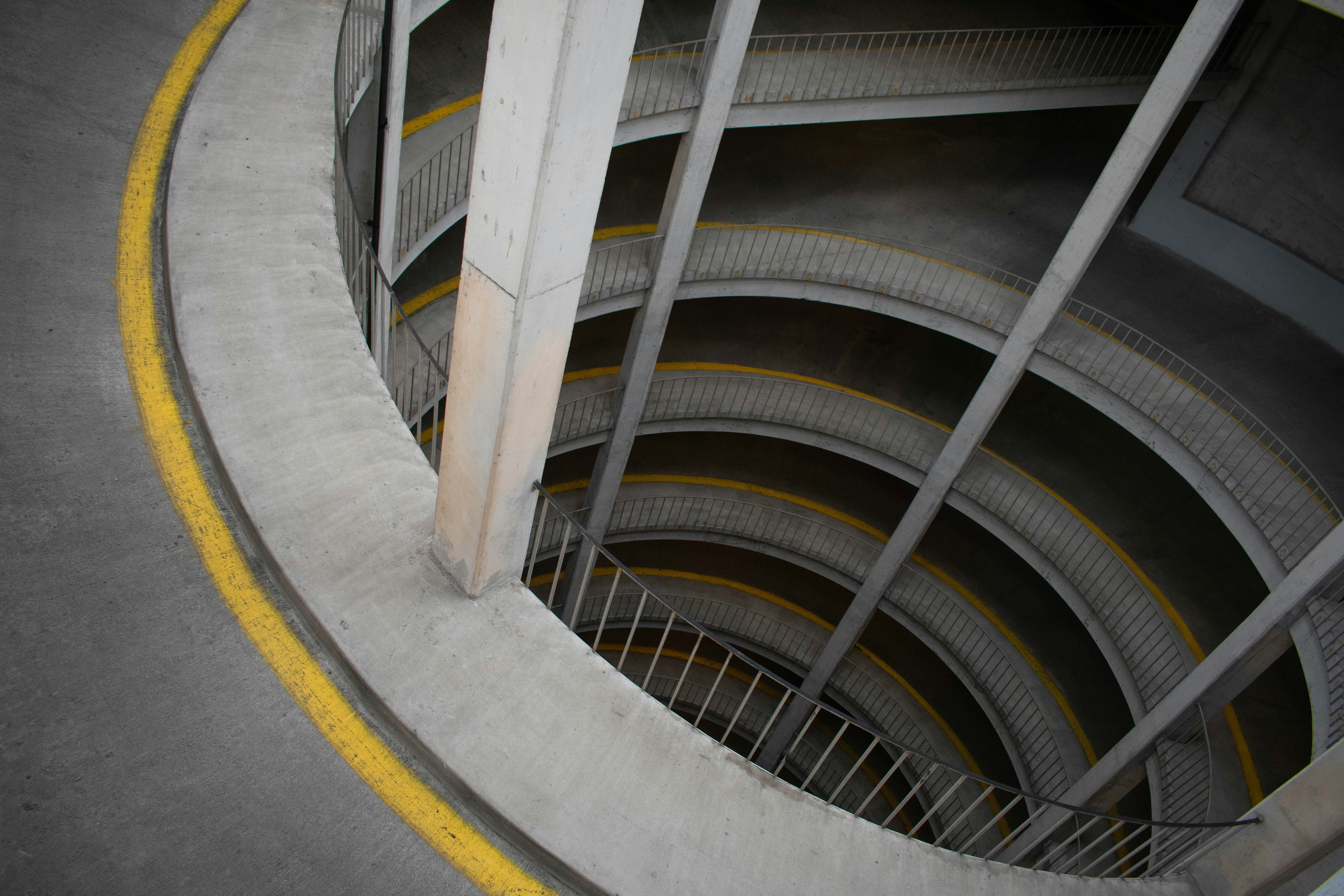 Spiral Descent: Neon-edged Concrete Rings in a Quiet Parking Atrium