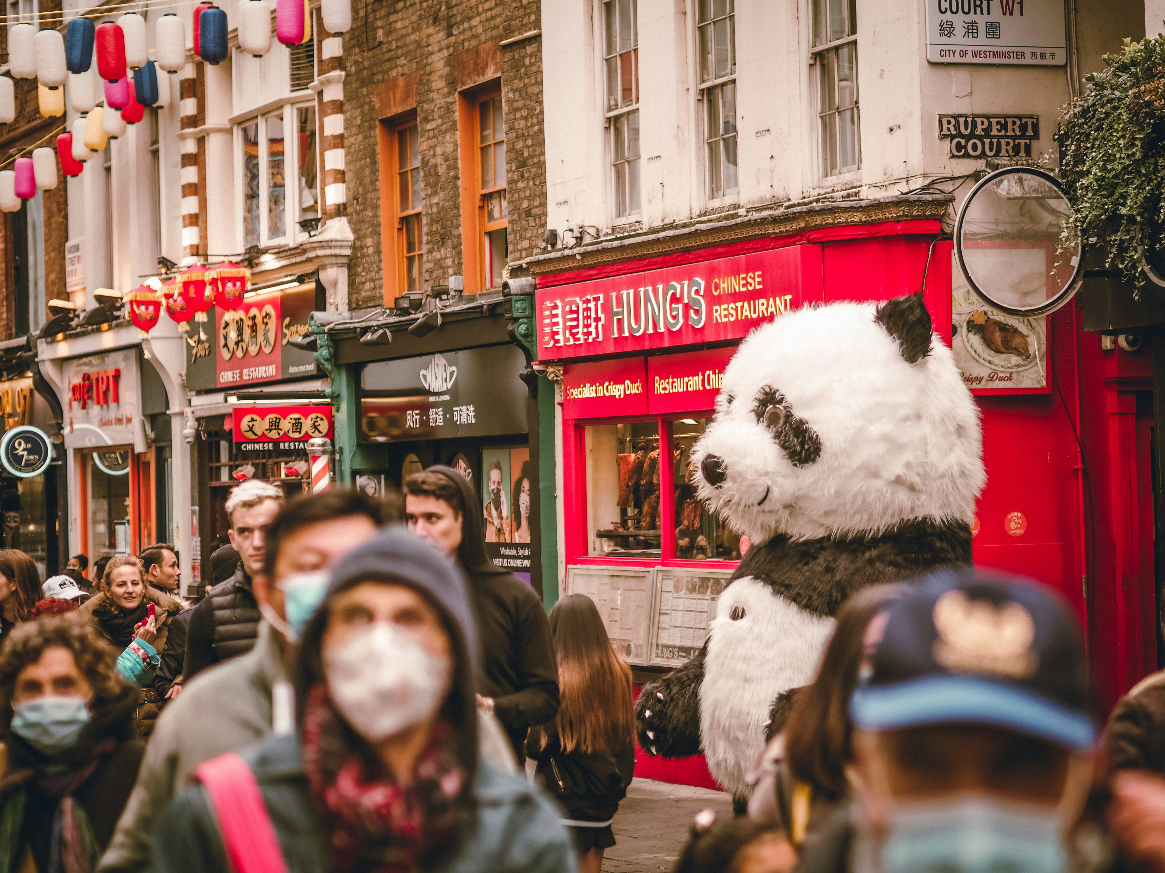 Panda Parade along a lively Chinatown street with a red storefront