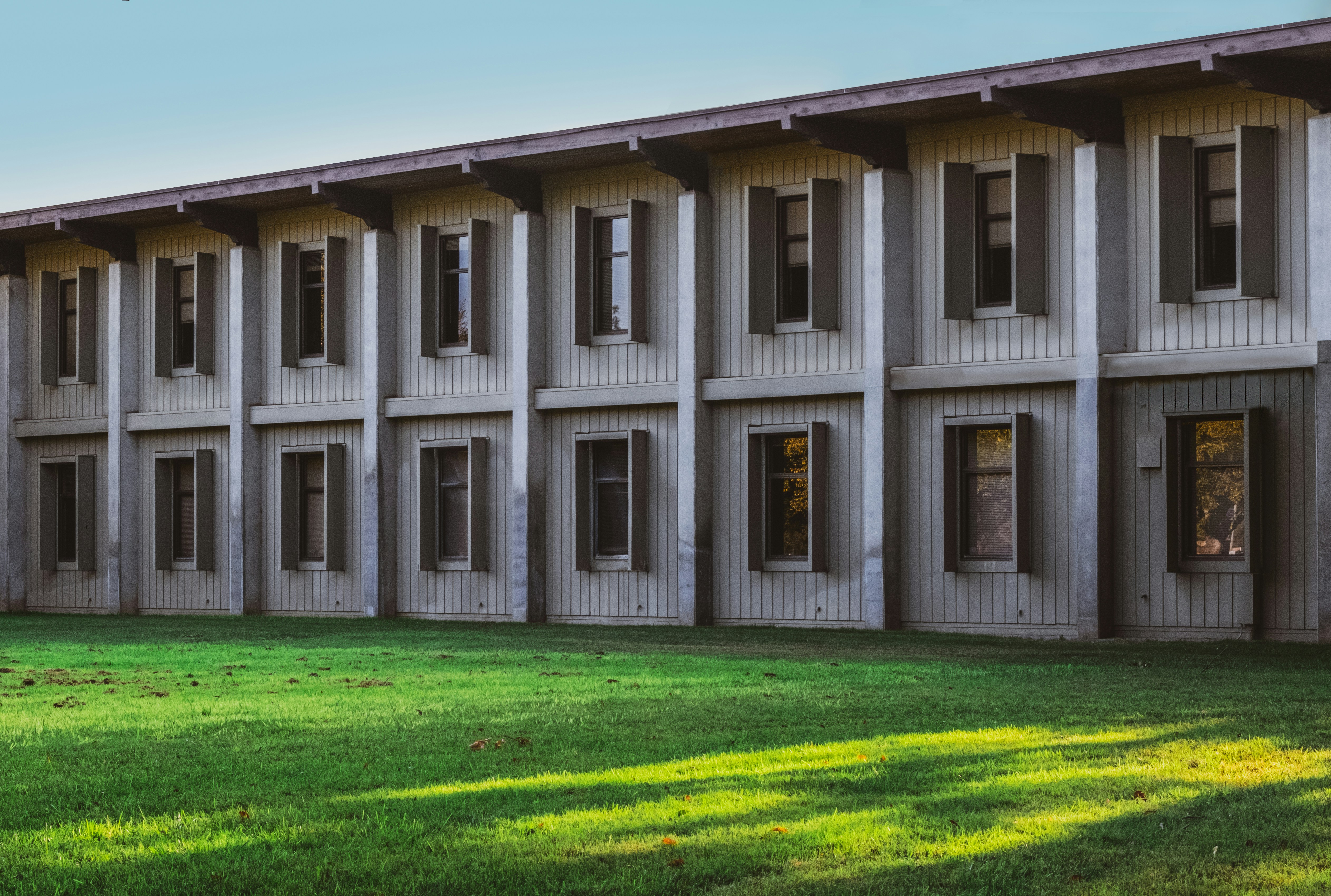 Grass in front of grey wooden building.