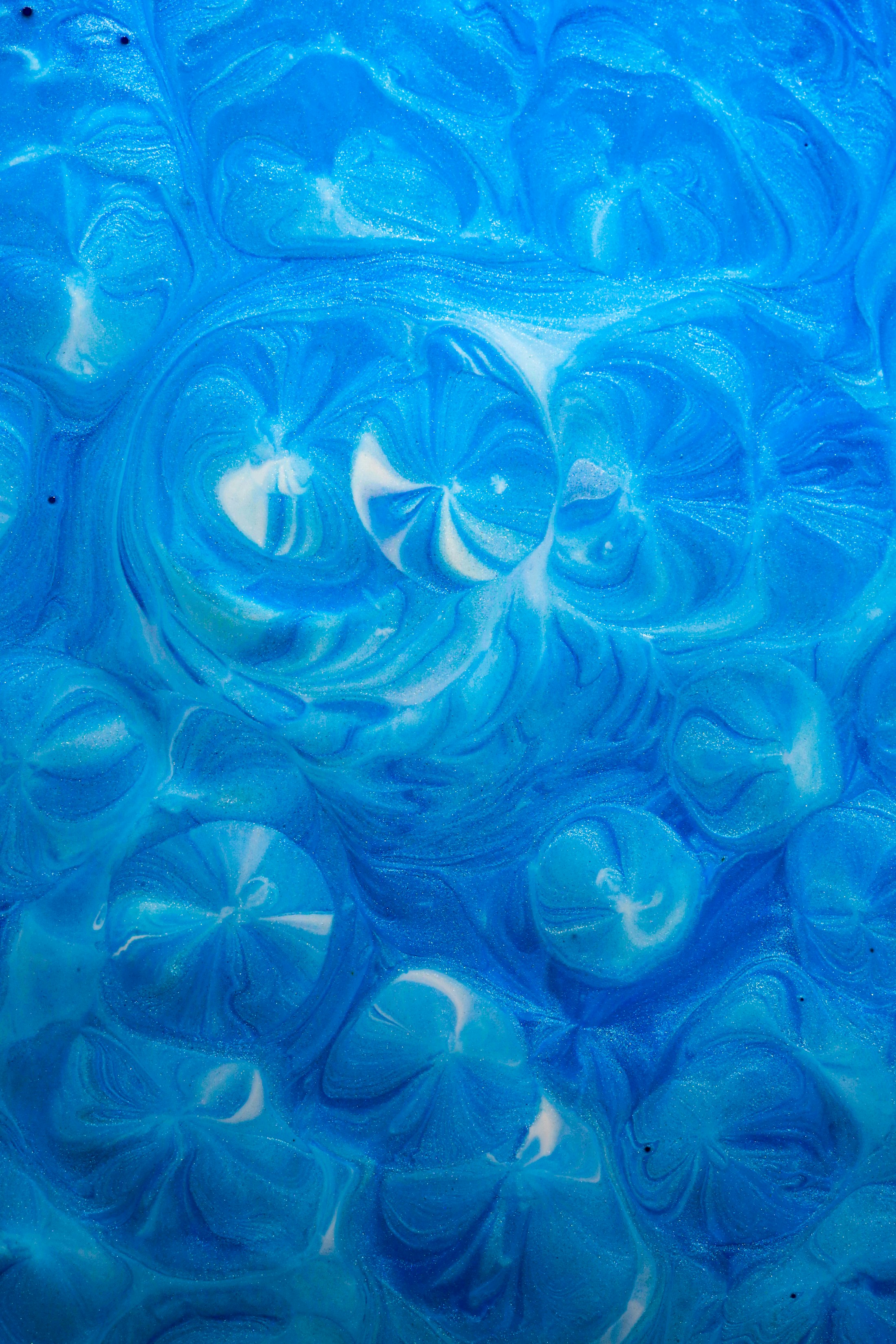 Vibrant blue abstract patterns swirl together, creating a mesmerizing texture that evokes the depths of the ocean.