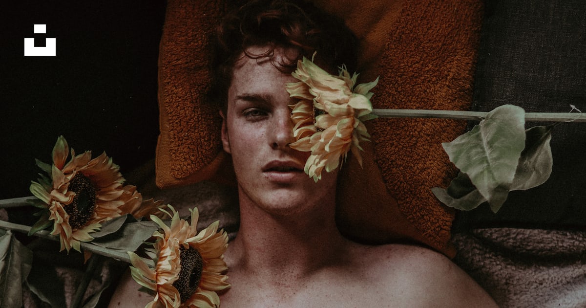 Homme Aux Seins Nus Avec Une Coiffe Florale Dorée Et Verte Photo